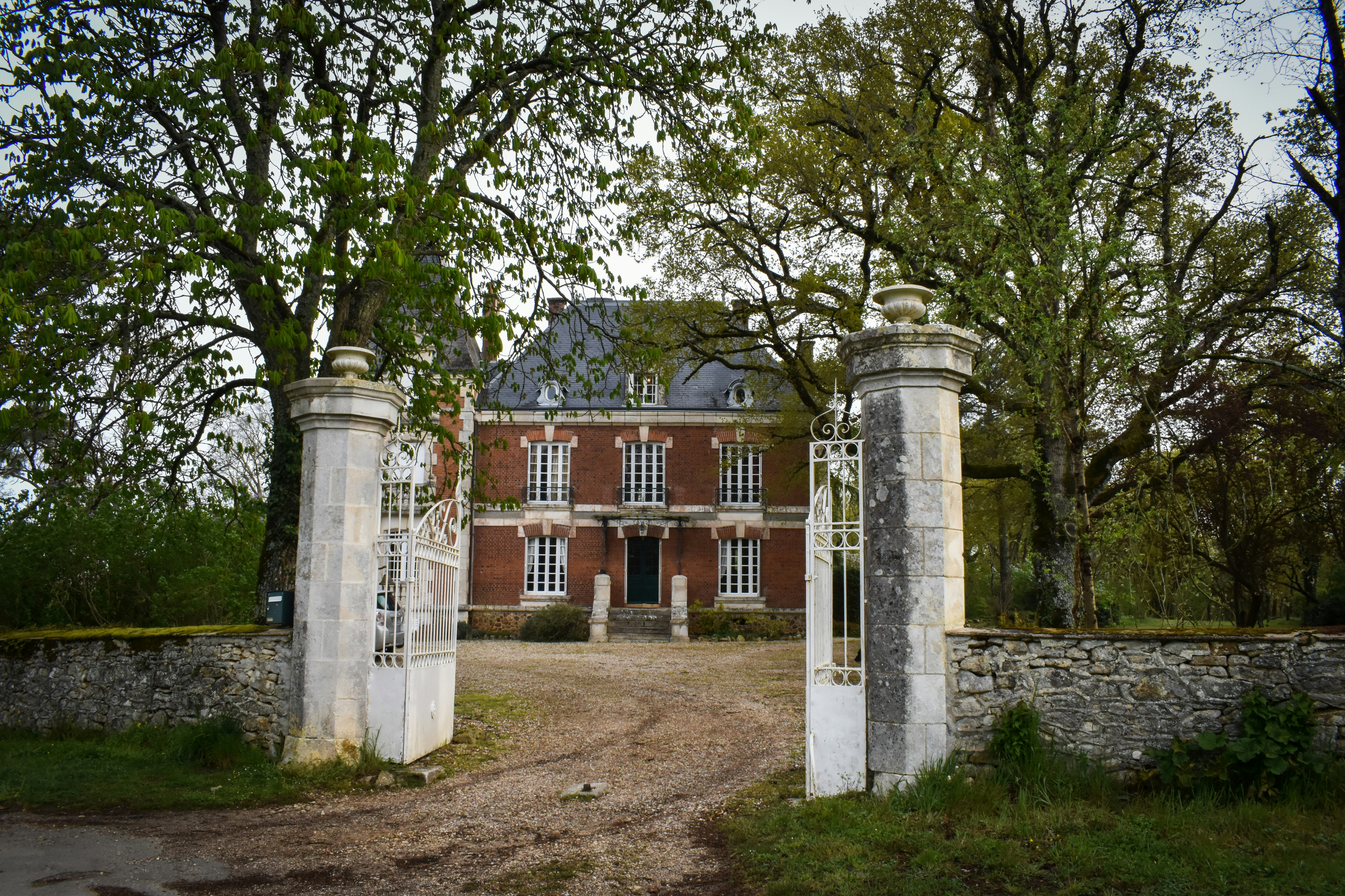 A large brick building with two white pillars photo – Free House Image ...