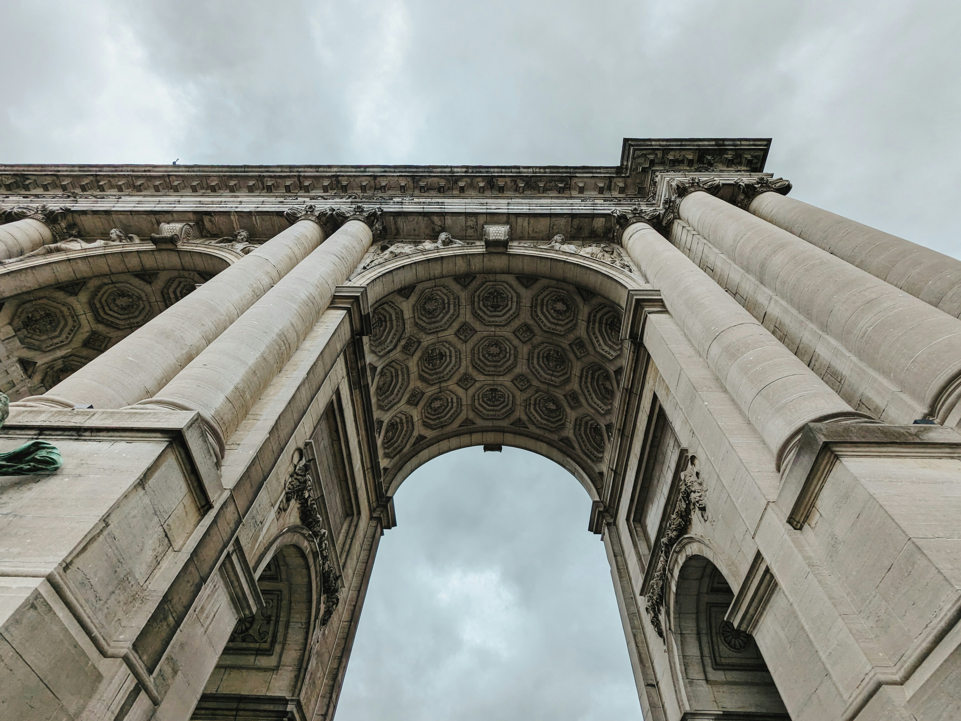 Looming Archway: Carved Stone Framing a Clouded Sky