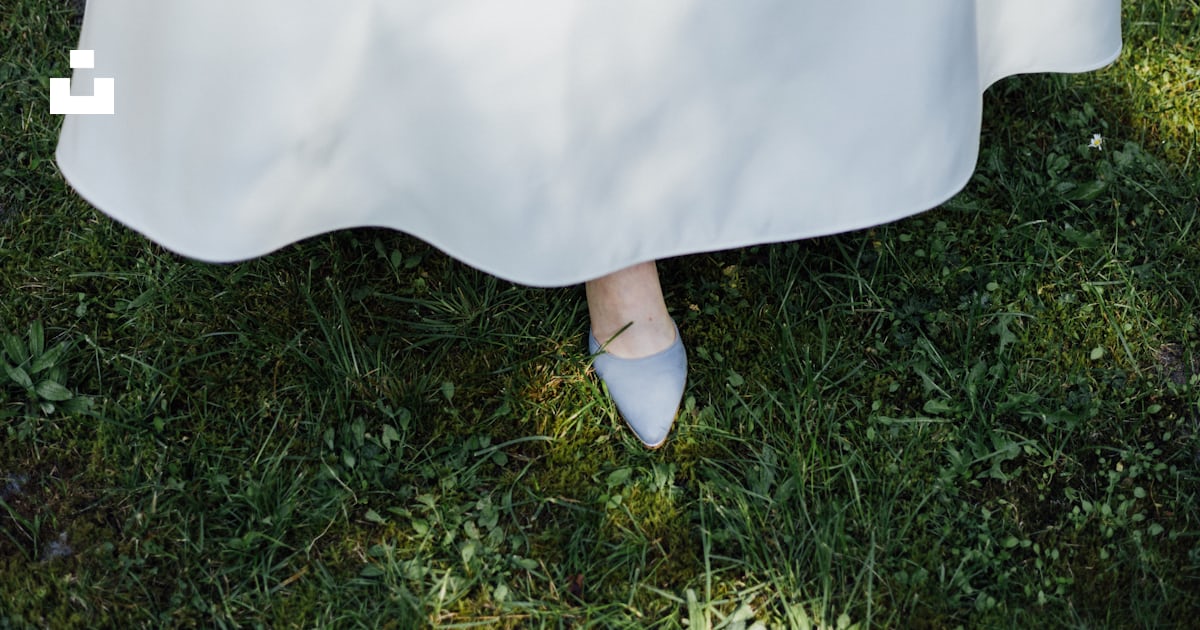 하얀 드레스를 입은 여자가 풀밭에 서 있다 사진 Unsplash의 무료 구두 이미지