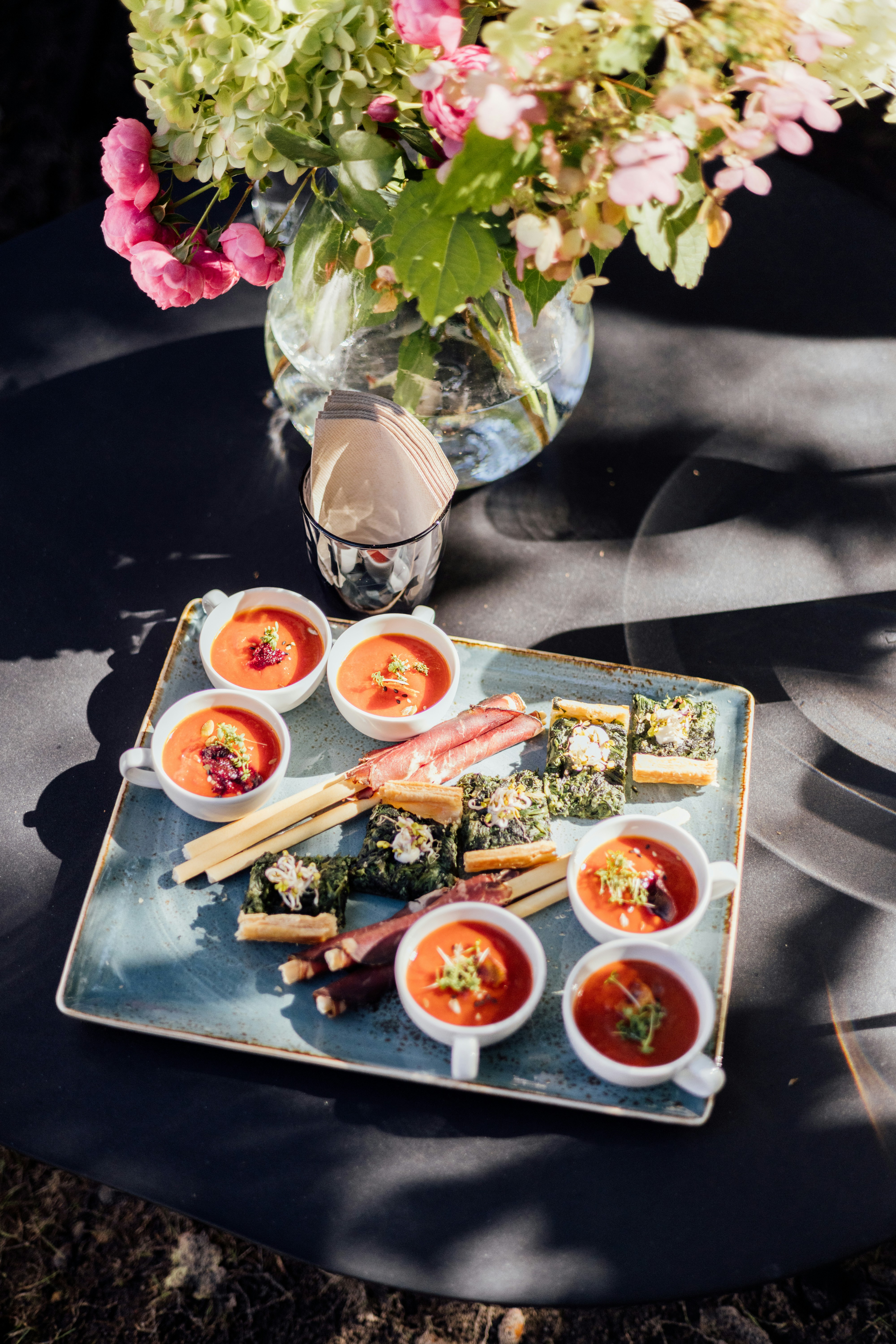 Sunlit Tapas Tray Beneath a Floral Cascade