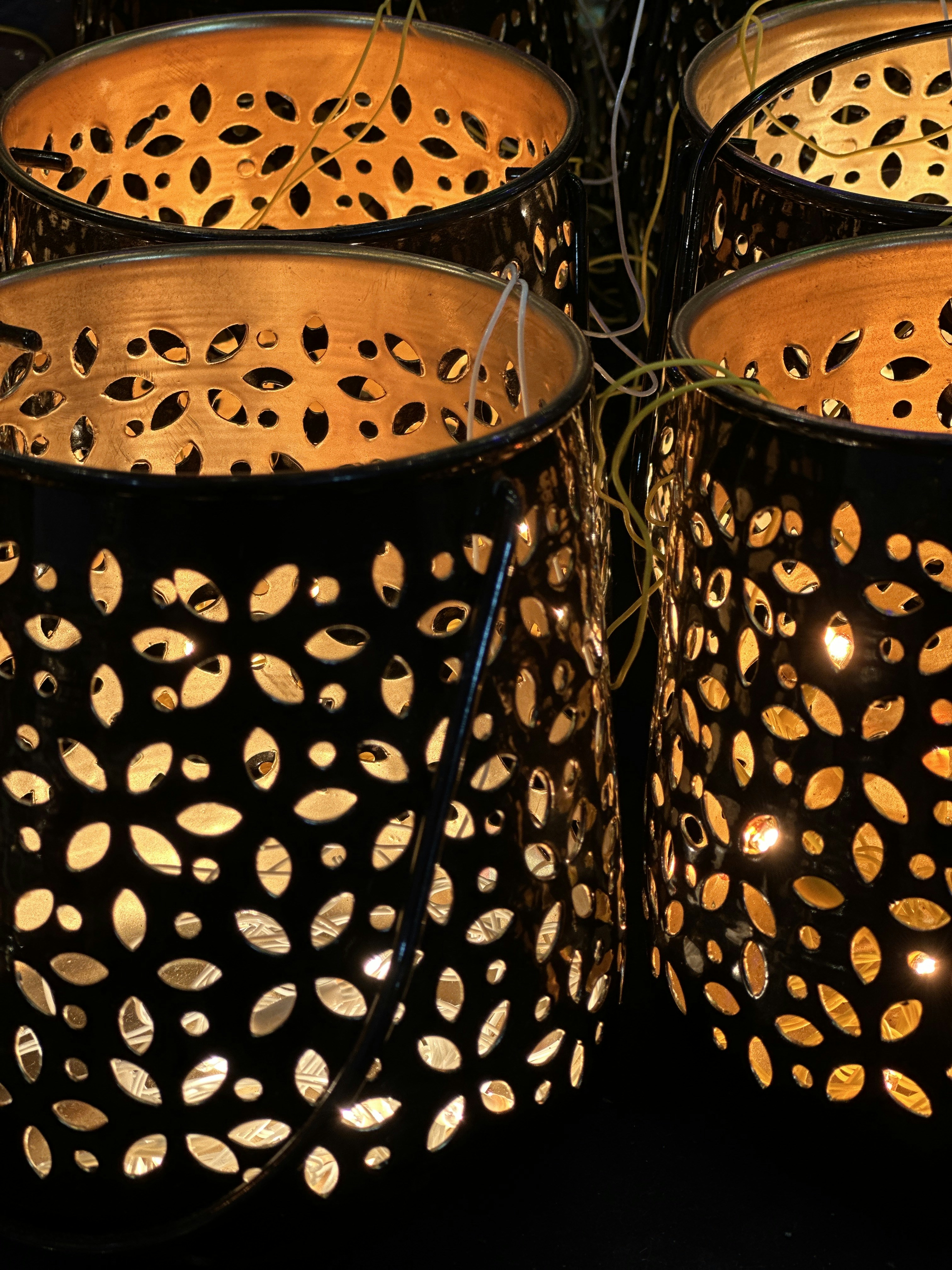 Amber Lattice Lanterns: Close-Up of Warm Light Through Leaf-Patterned Metal