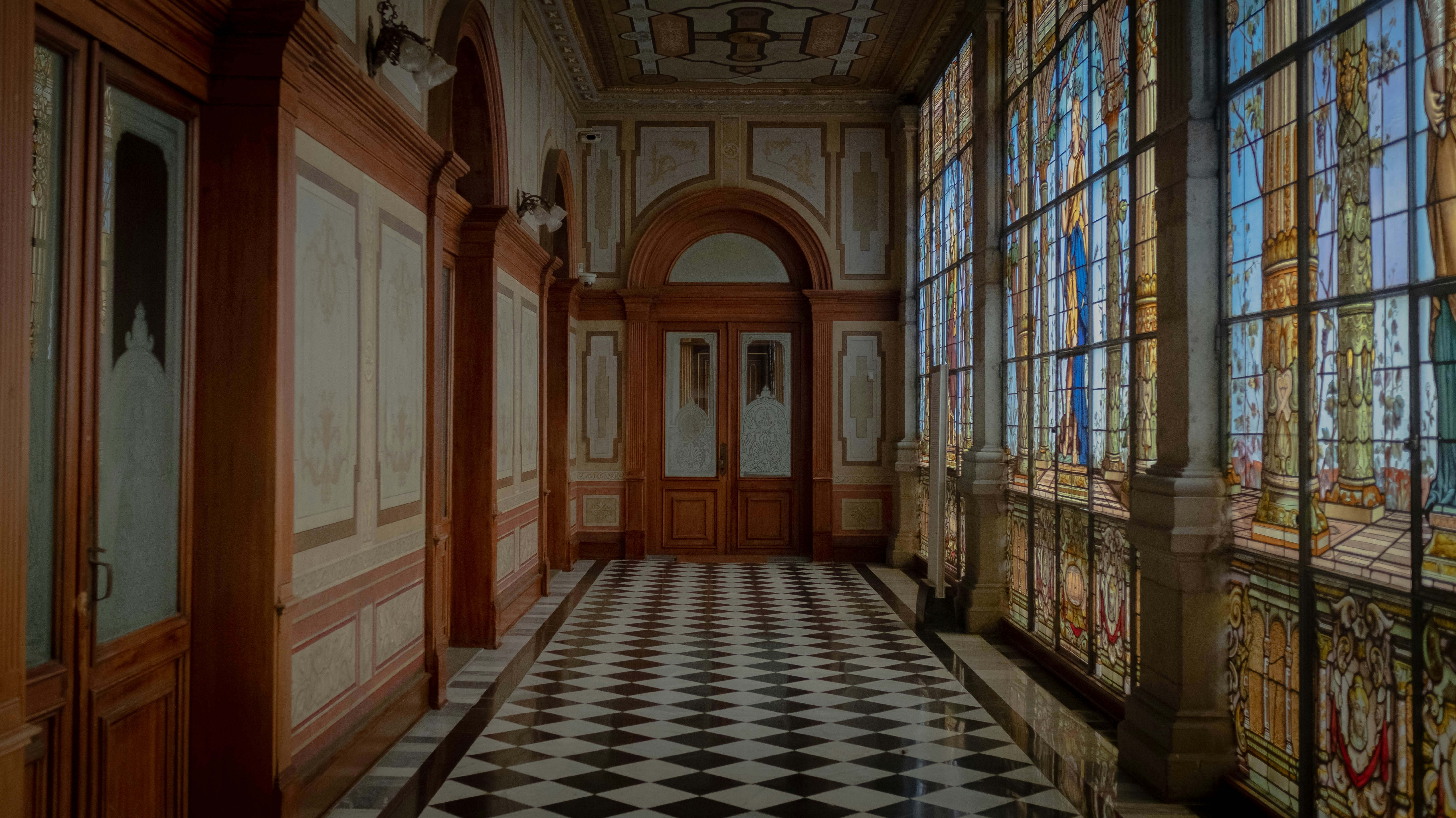 A hallway with stained glass windows and a checkered floor photo – Free ...