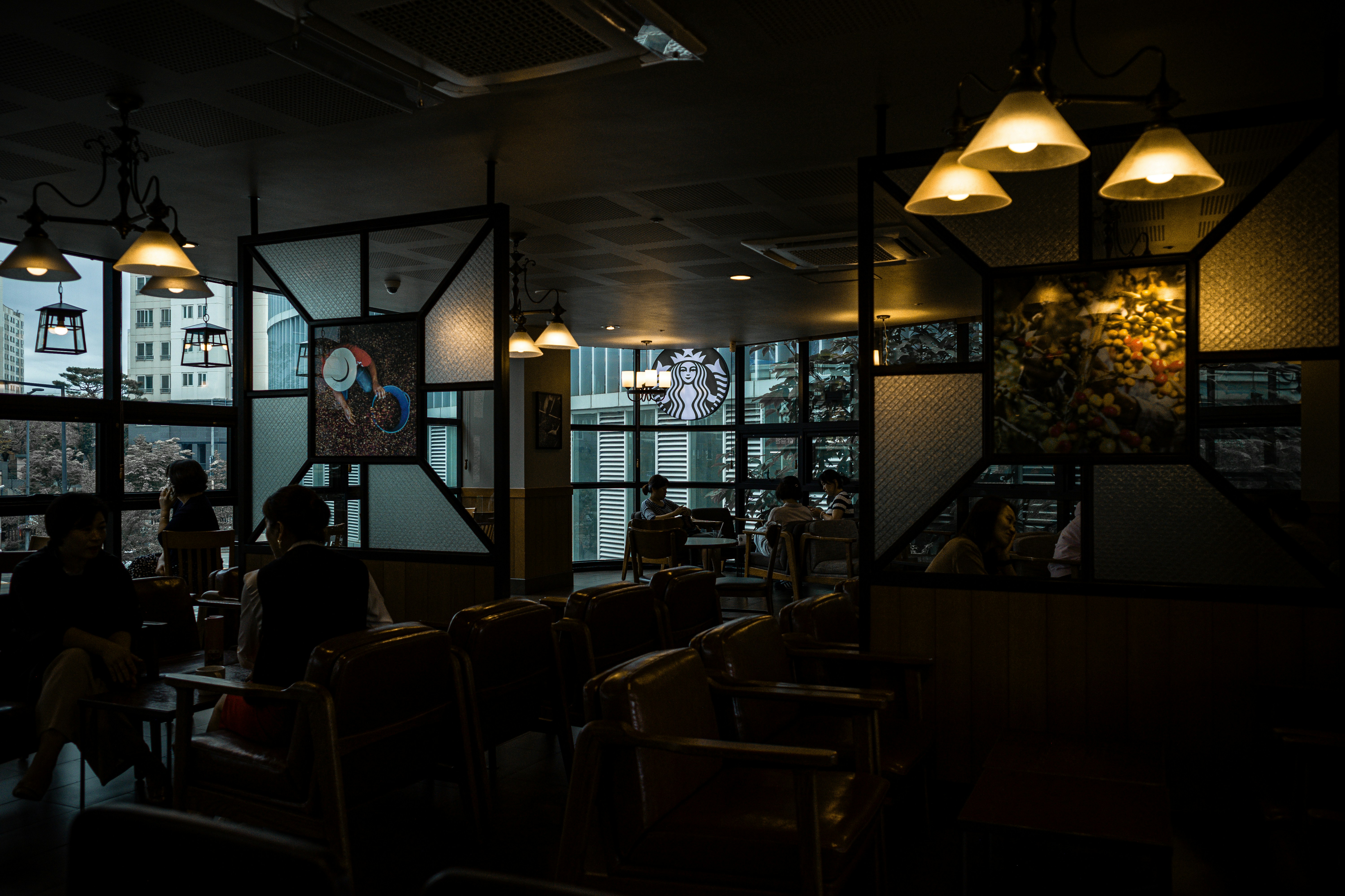 A dimly lit restaurant with people sitting at tables photo – Free Cafe ...