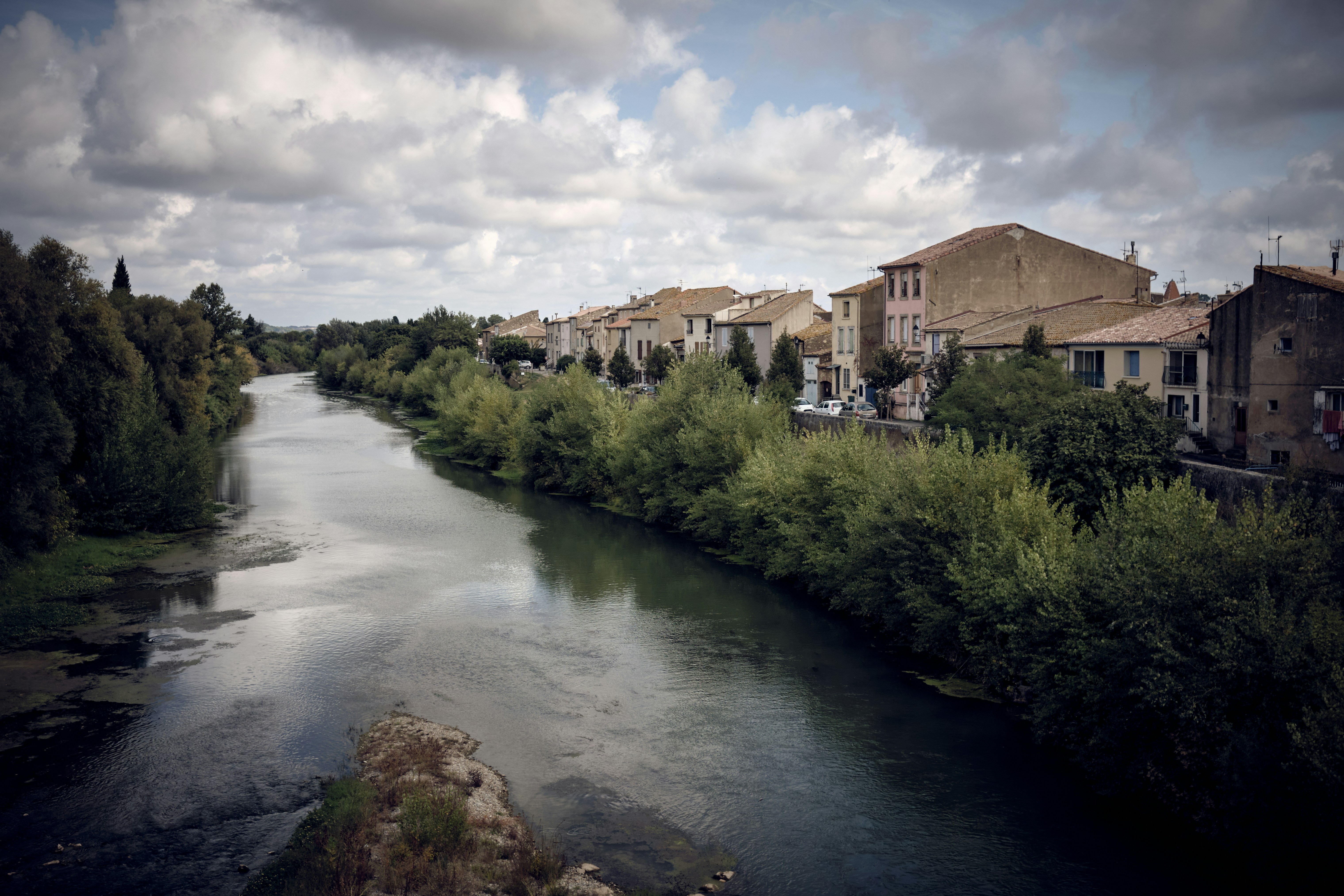 Riverside Village in Soft Light: Stone Facades Framed by Verdant Banks