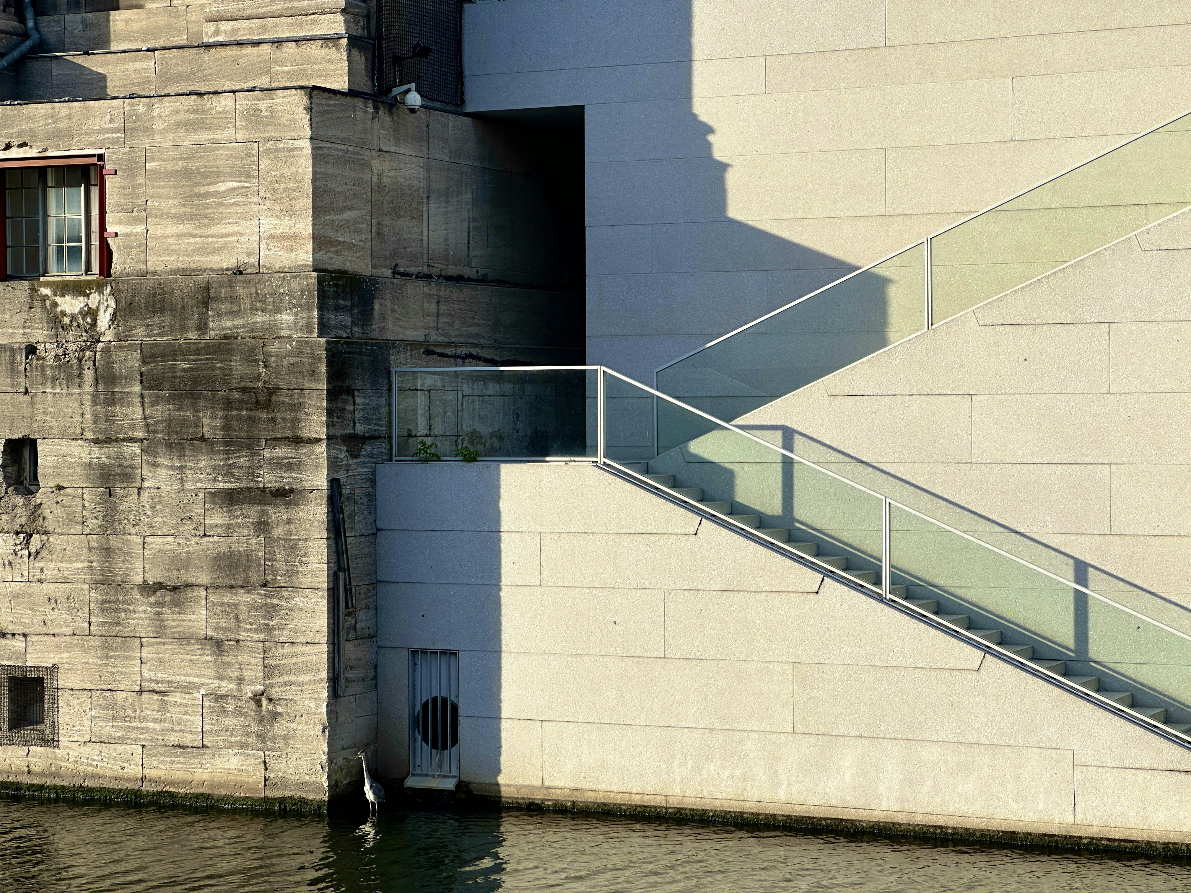 Geometric Staircase Traces Geometry Across Waterfront Facade