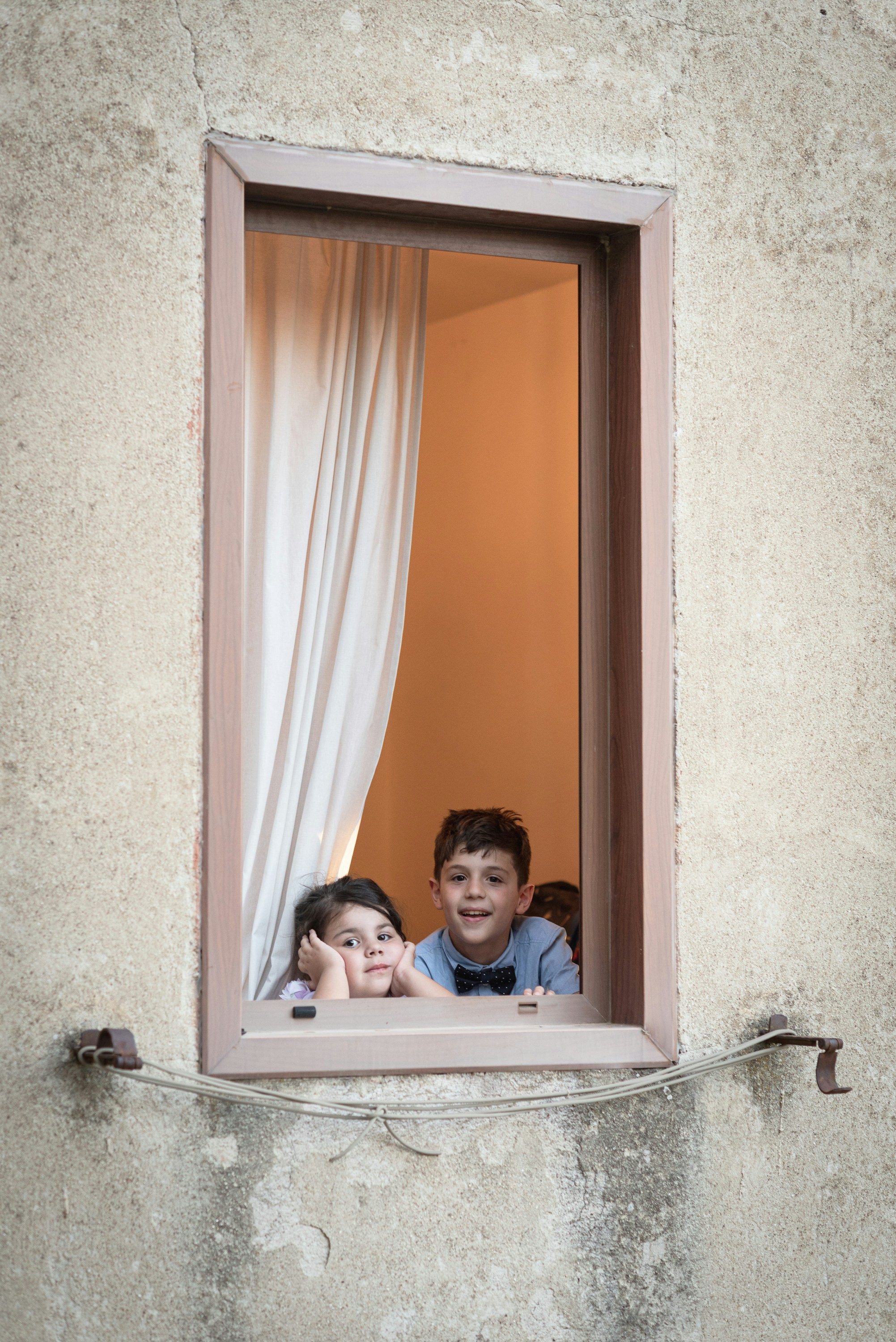 Window of Curiosity: Three Smiles Framed by Morning Light
