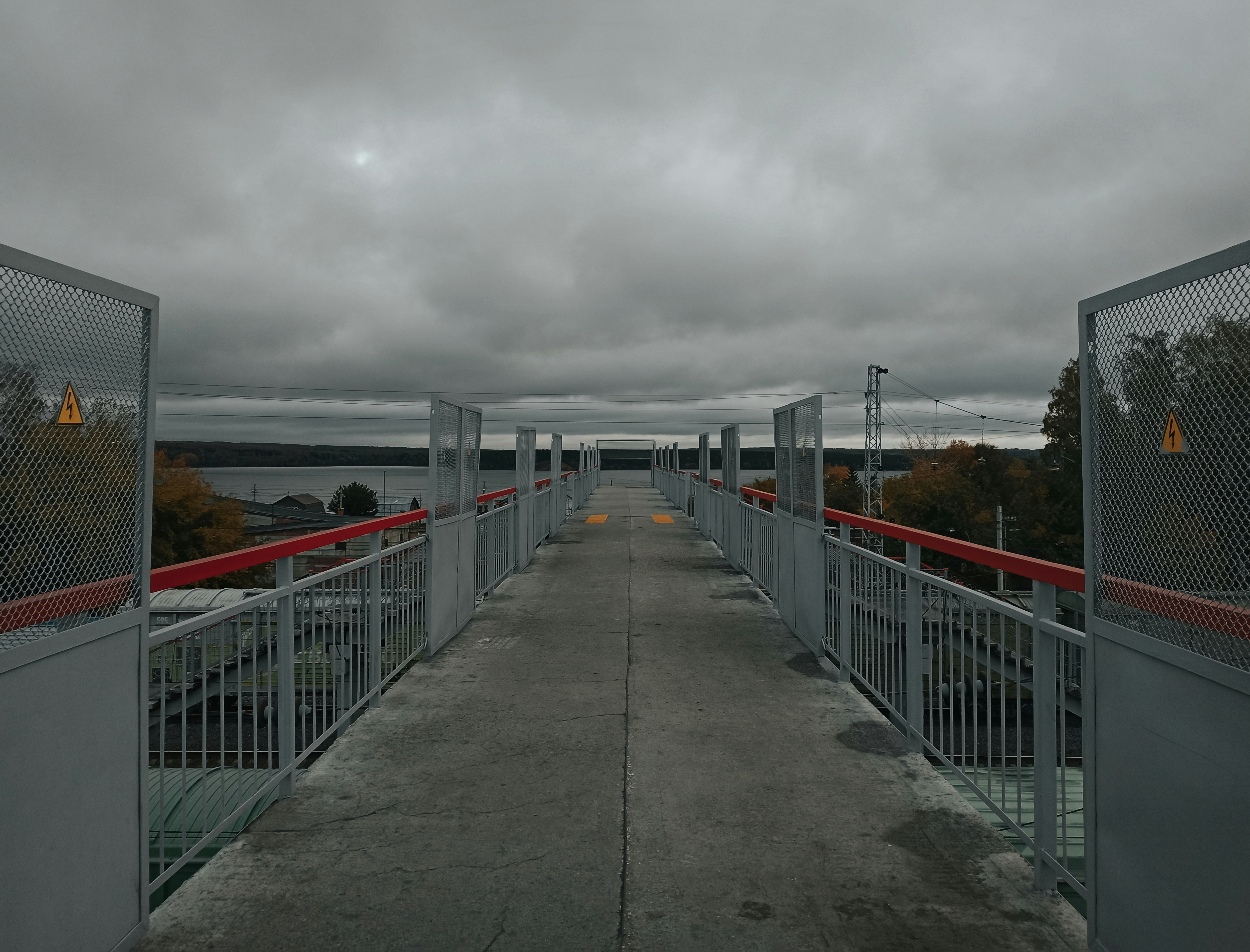 Convergence on a Cloudy Horizon: A Steel Walkway Toward the Sea