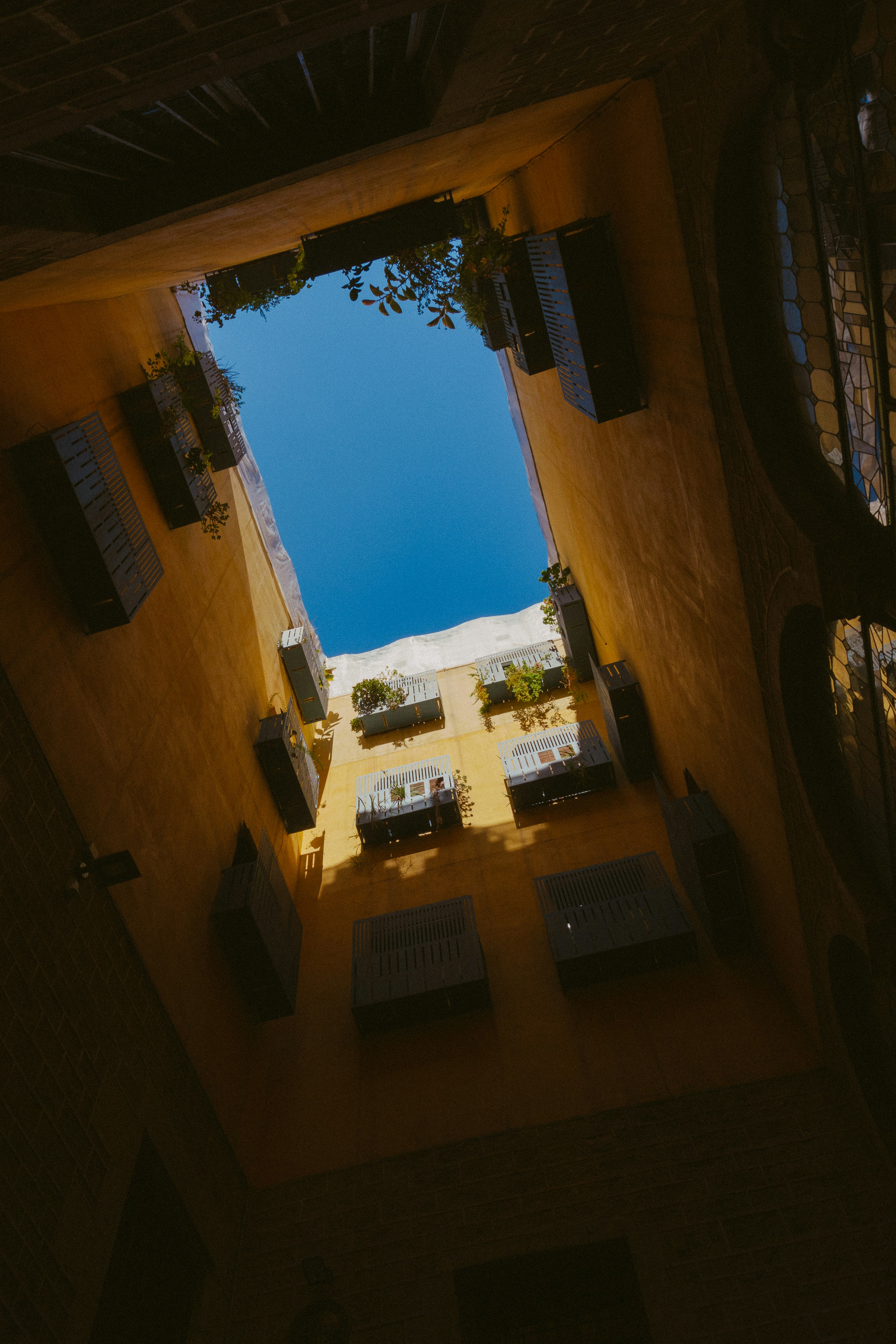 Azure Opening: Sky Framed by a Sunlit Courtyard Shaft