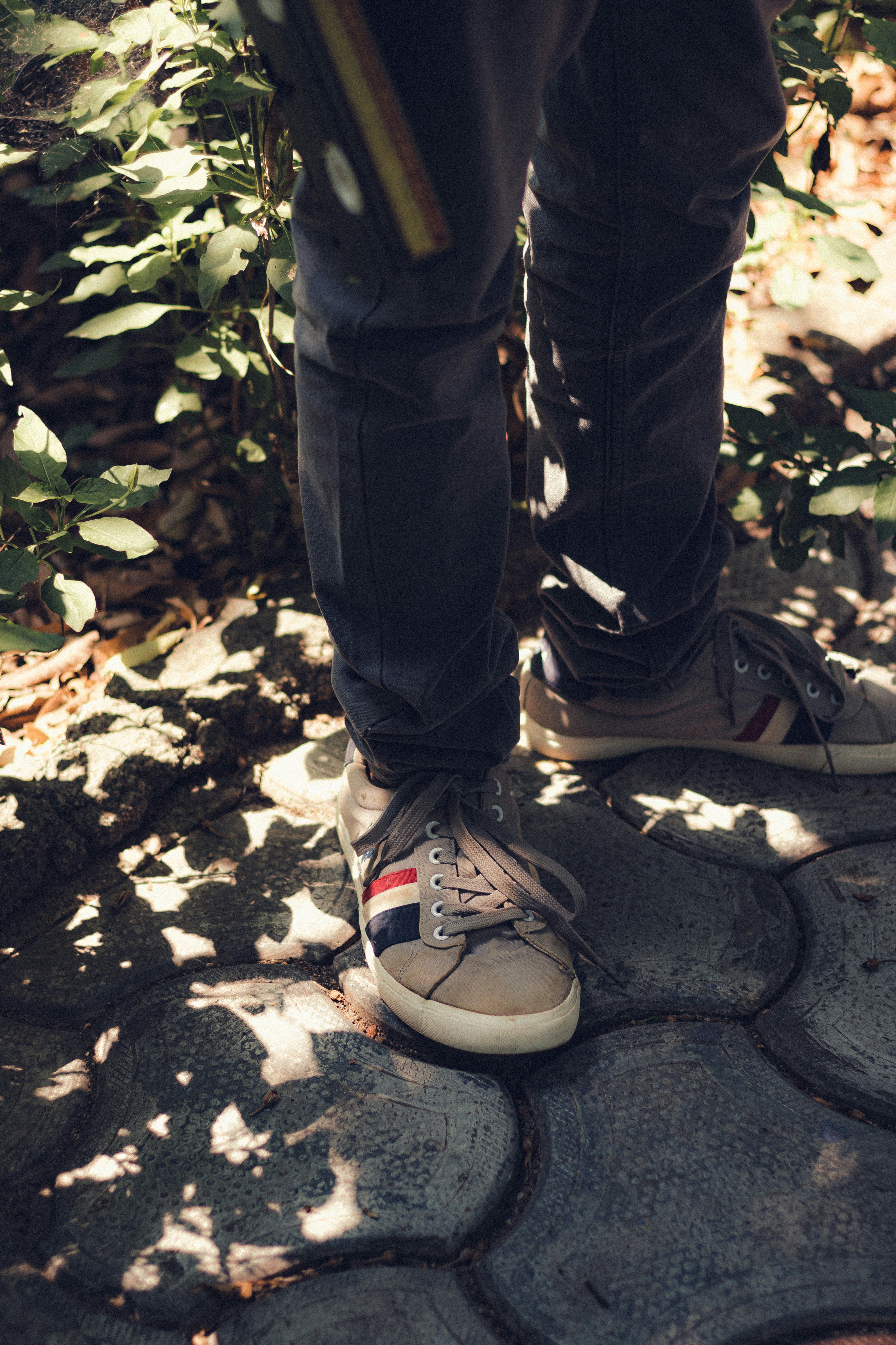 Stride in the Shade: Sneakers on a Sunlit Cobblestone Path