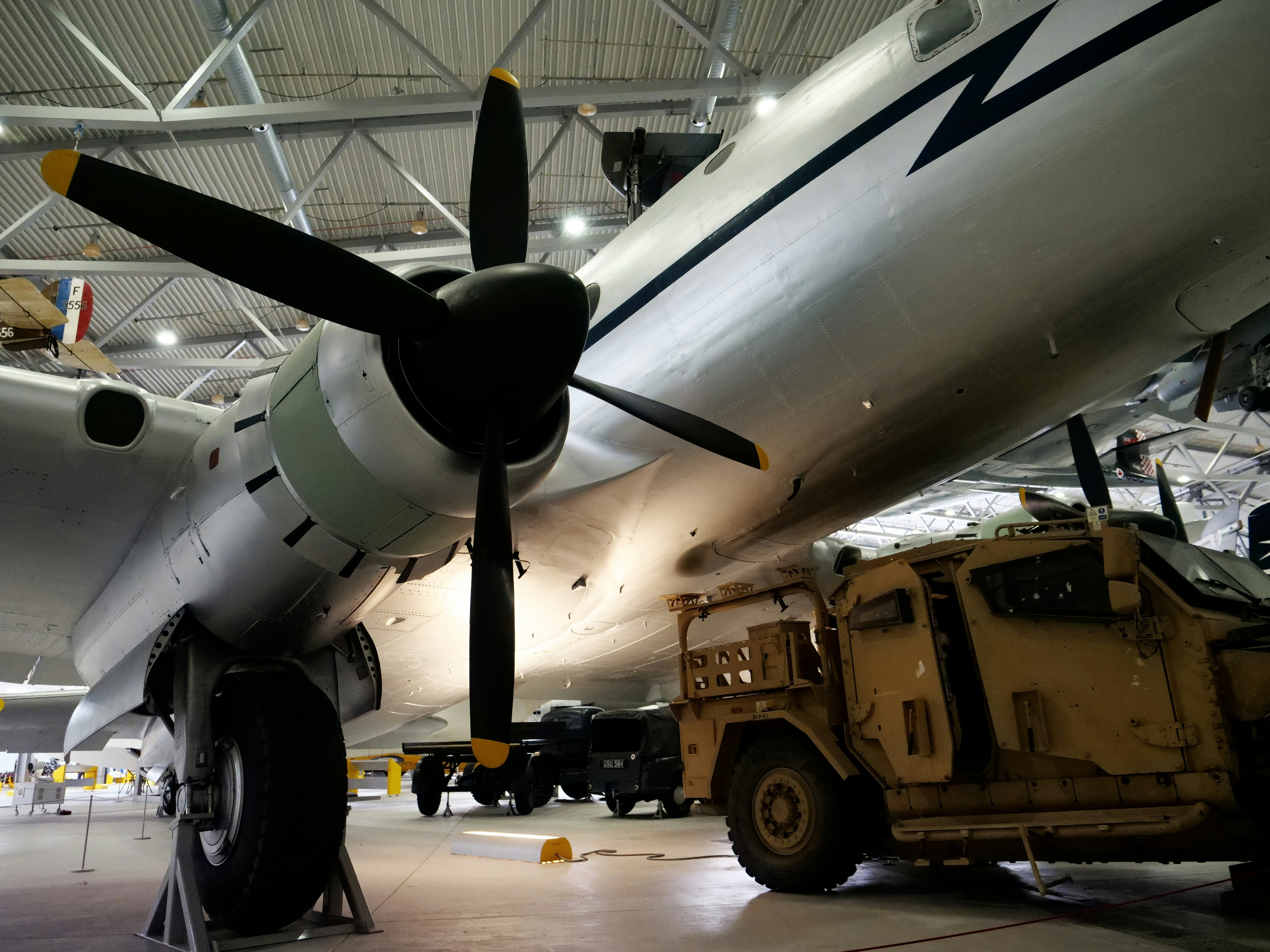 A large propeller plane sitting inside of a hangar photo – Free ...