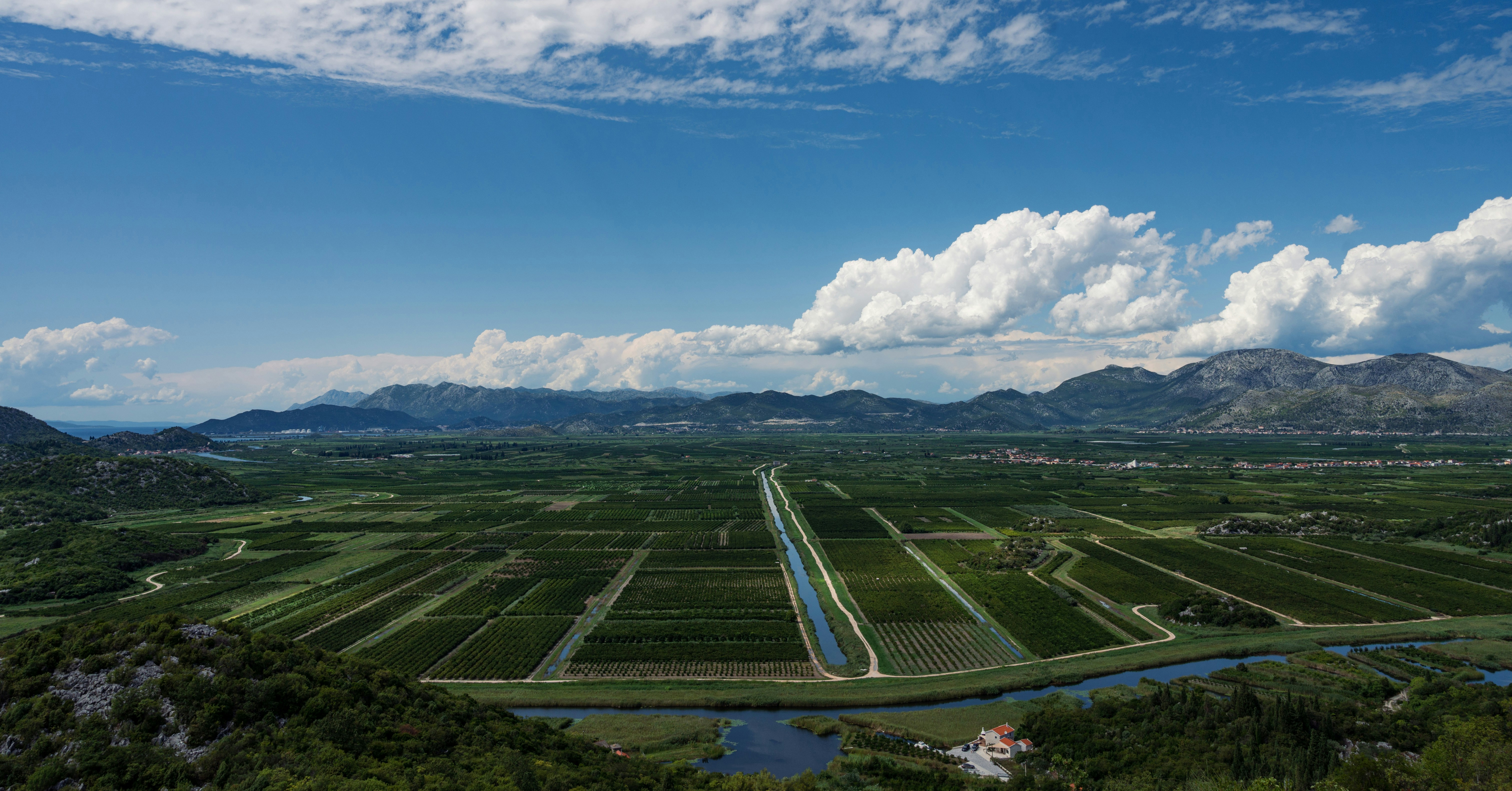 An aerial view of a field with a river running through it photo – Free ...