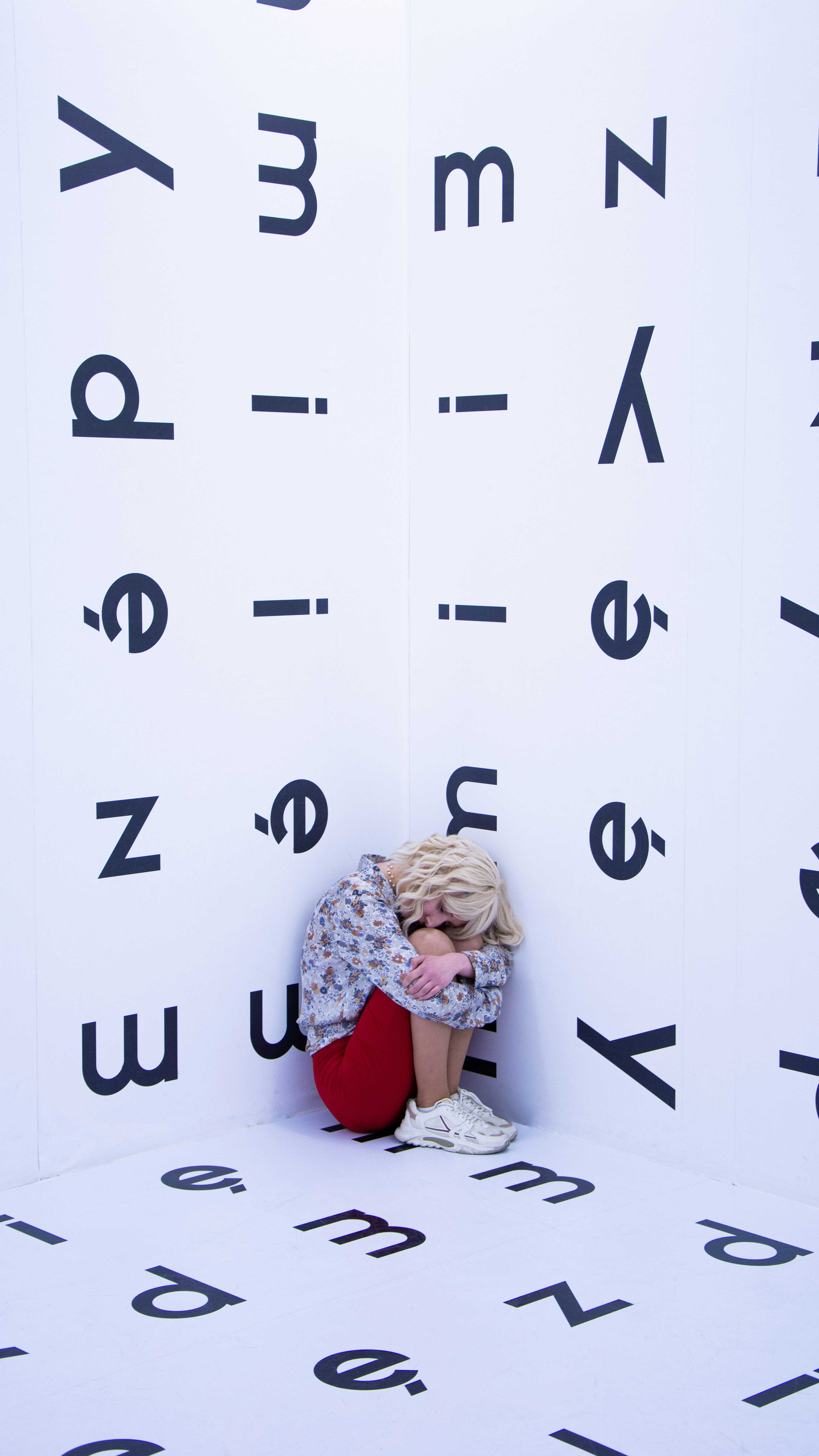Alone Among the Alphabet: A Quiet Figure in a Room of Oversized Letters