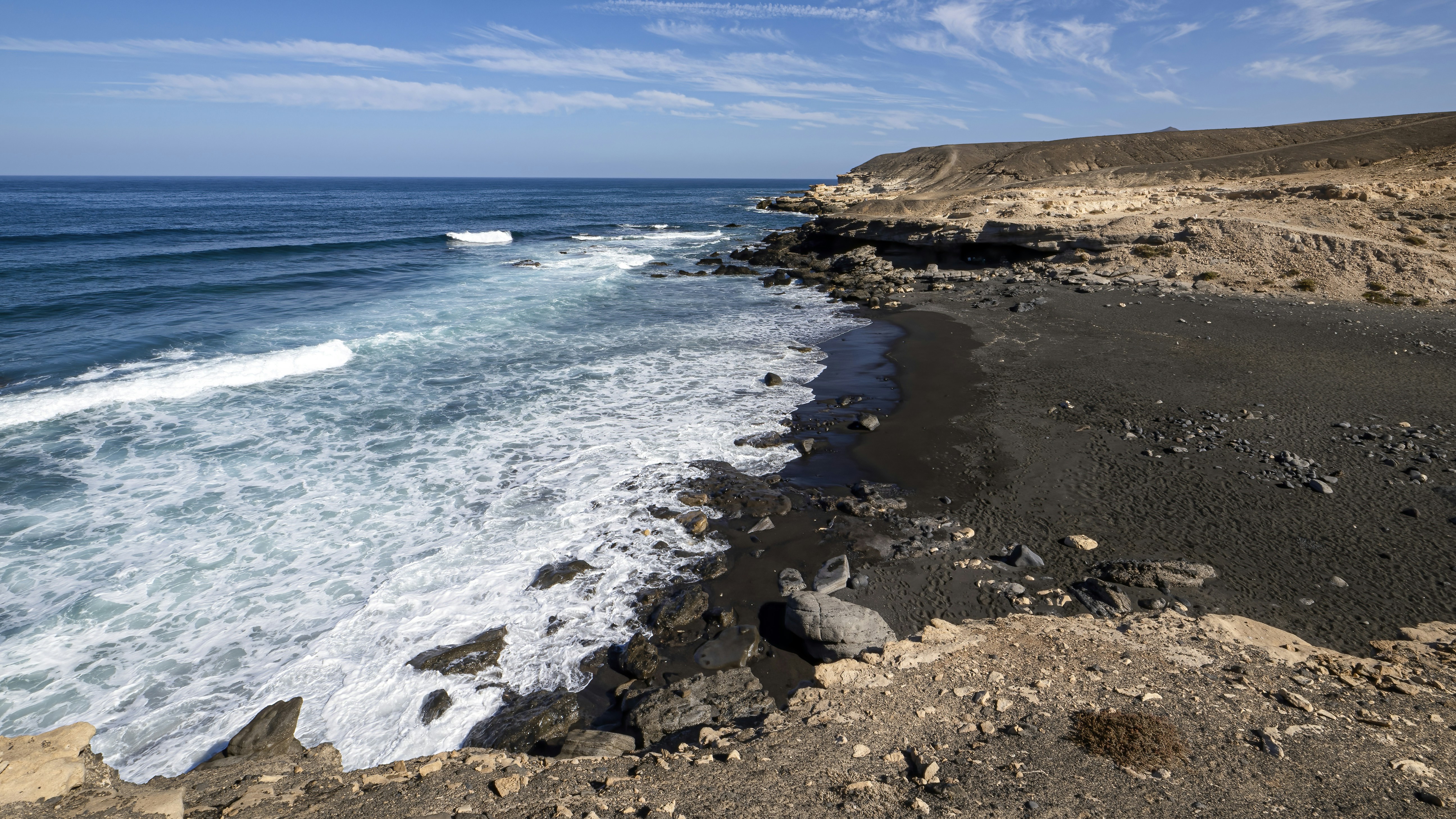 Foto zum Thema Ein felsiger Strand mit Wellen, die ans Ufer kommen ...