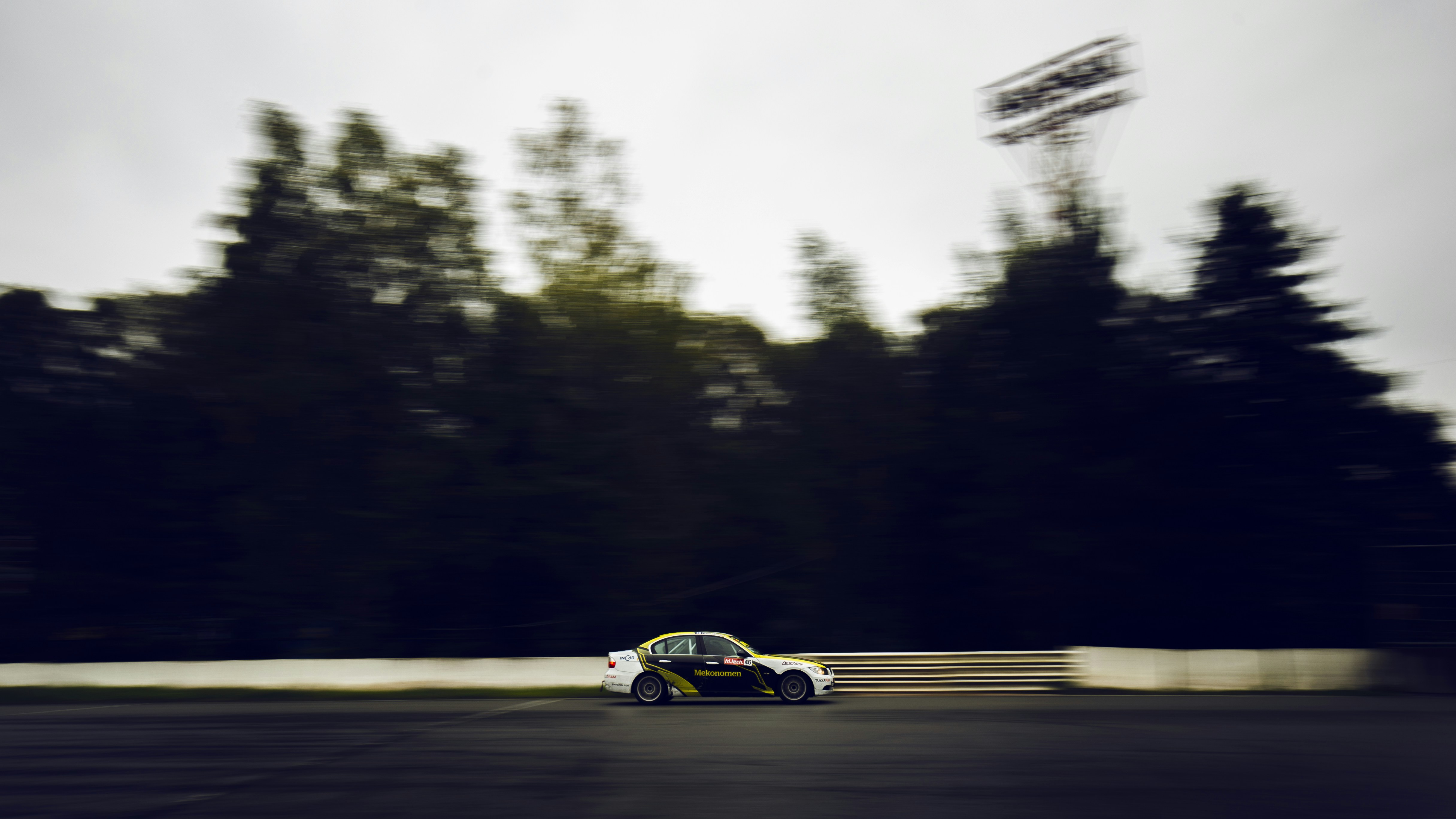 A car driving down a race track with trees in the background photo ...