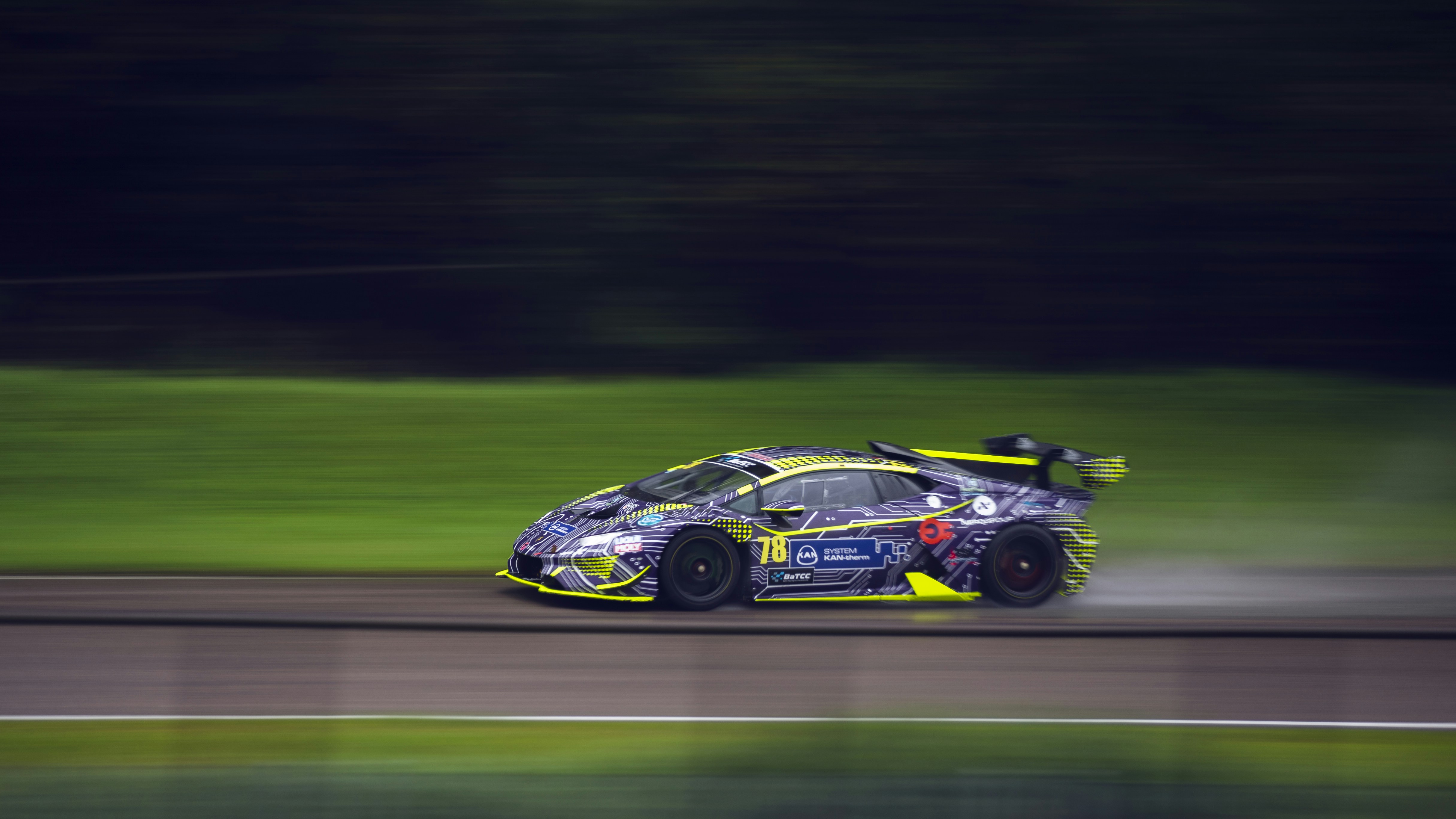A car driving down a race track with trees in the background photo ...