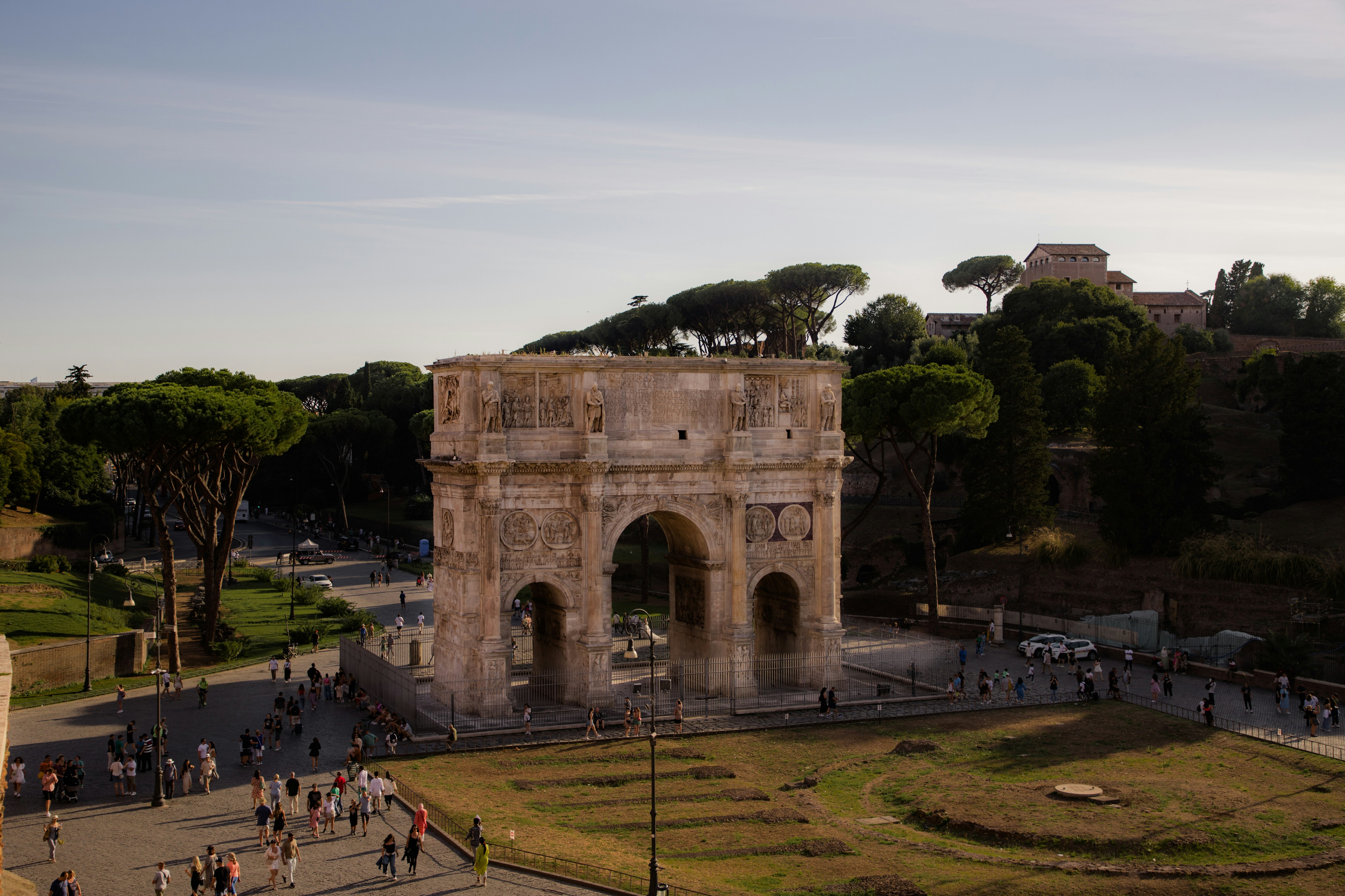 Morning light over the Arch of Constantine as crowds thread the Roman Forum