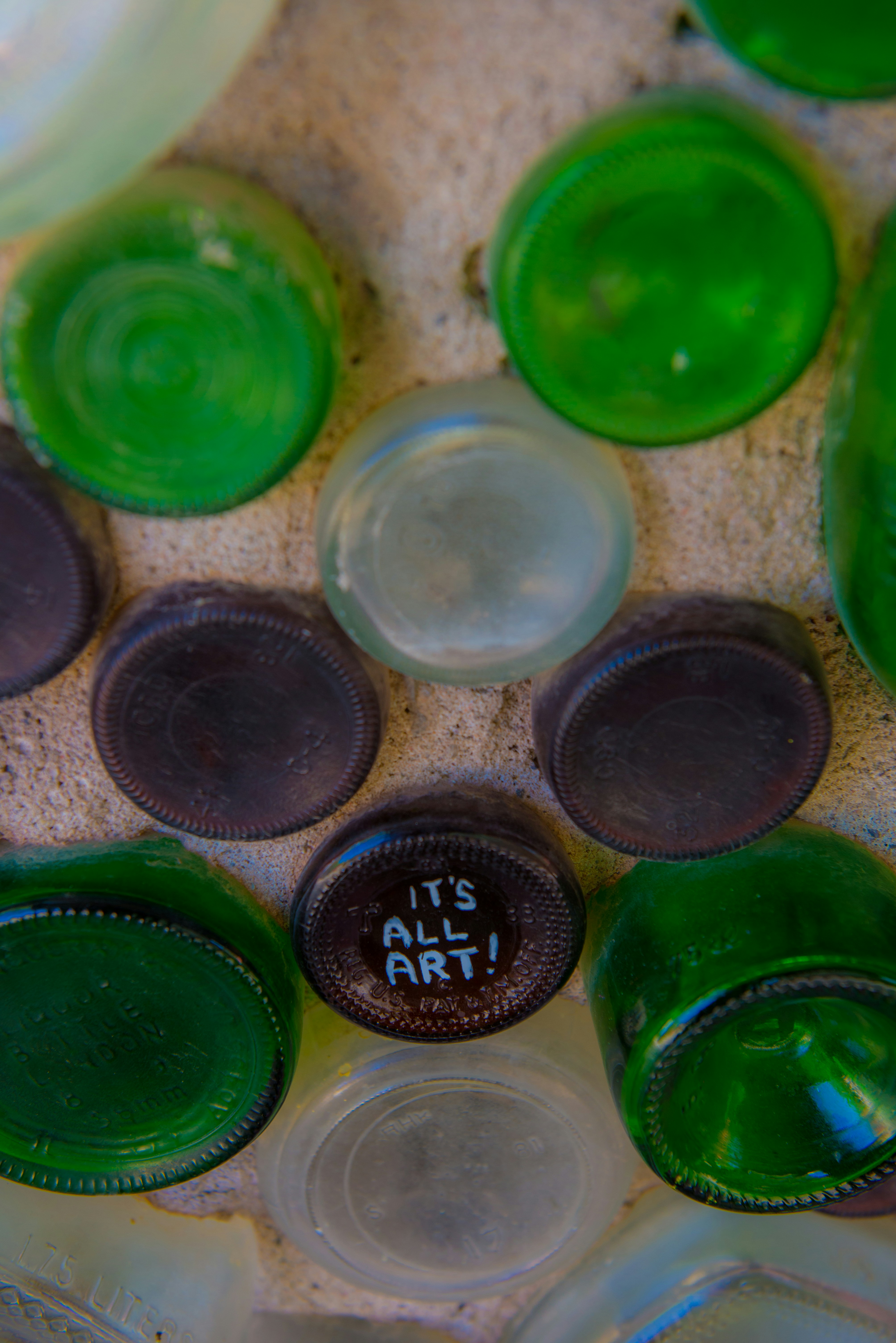 It's All Art on a Sandy Canvas: Close-Up of Bottle Caps