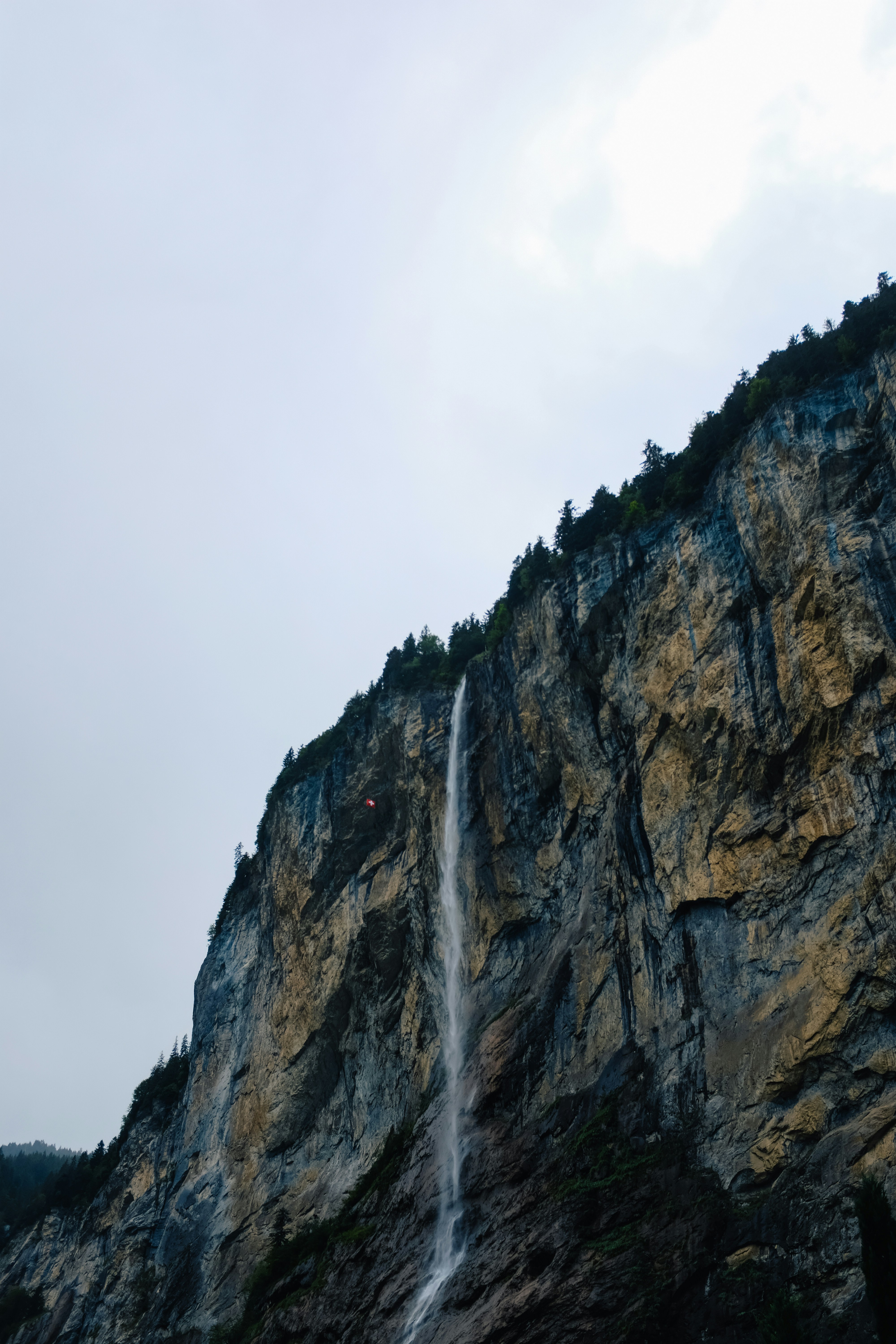 A tall waterfall falling down a mountain side photo – Free Cliff Image ...