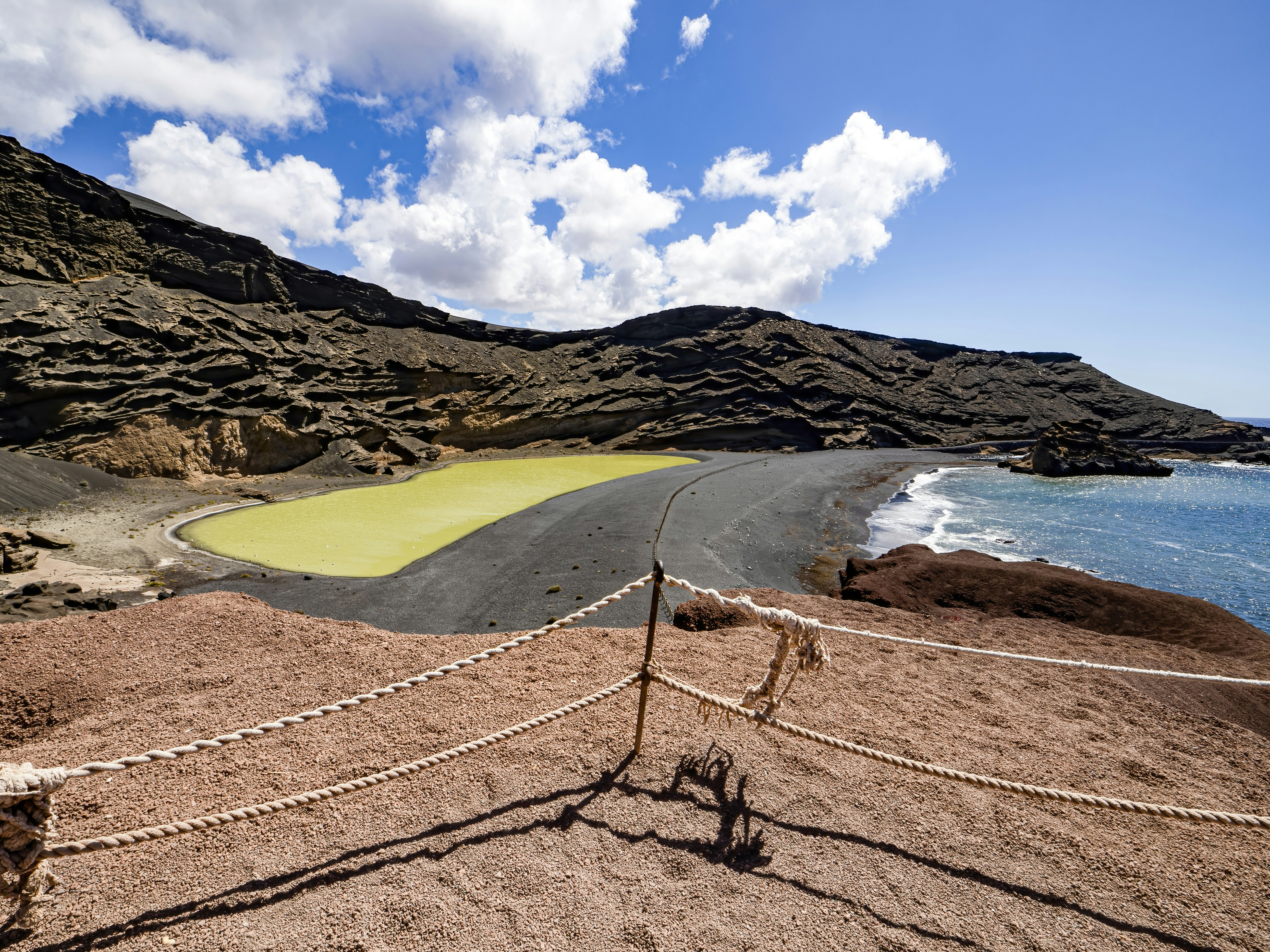 A roped off area with a body of water in the background photo – Free ...