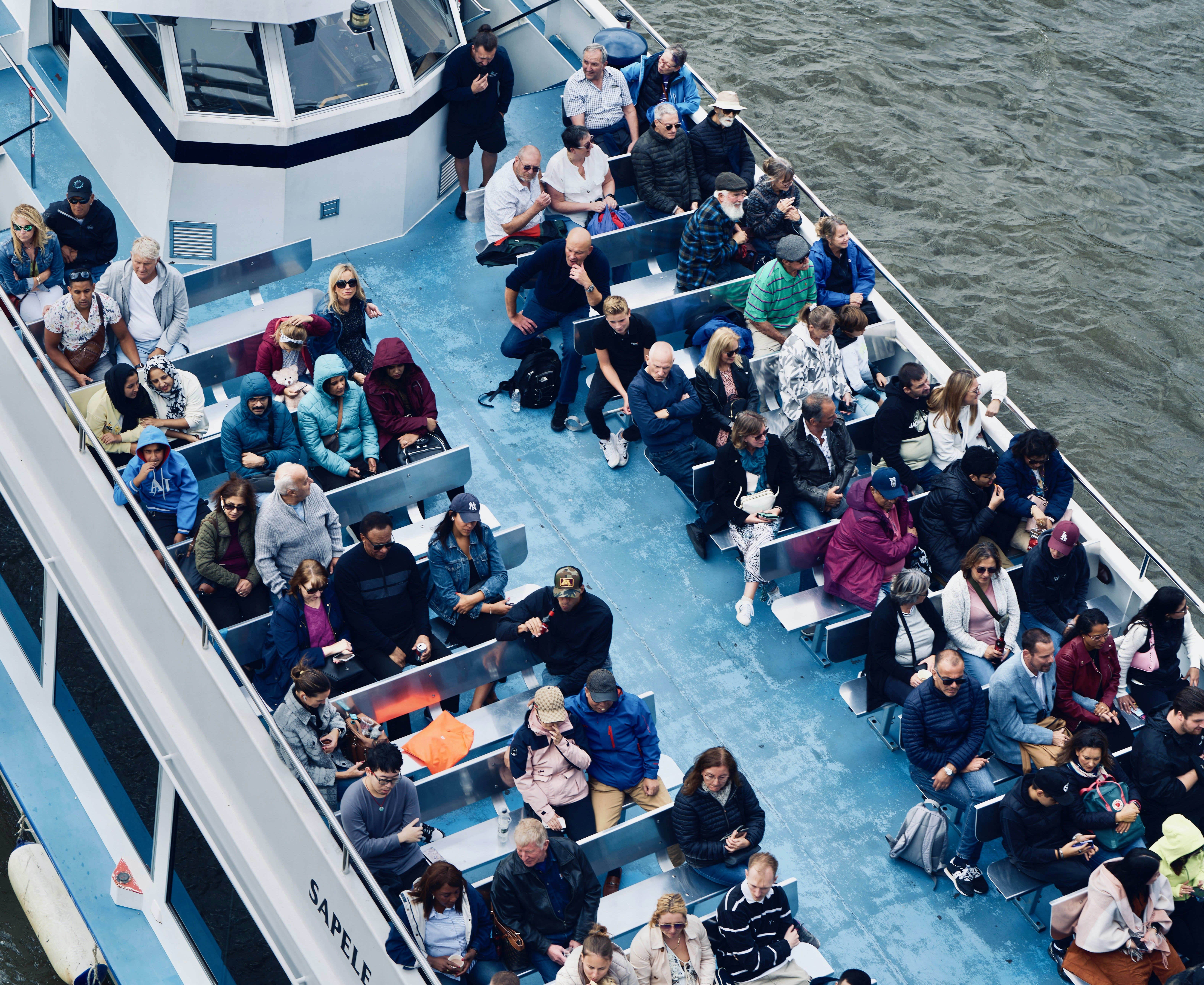 Overhead Mosaic: Passengers on a Blue-Floor Ferry Deck