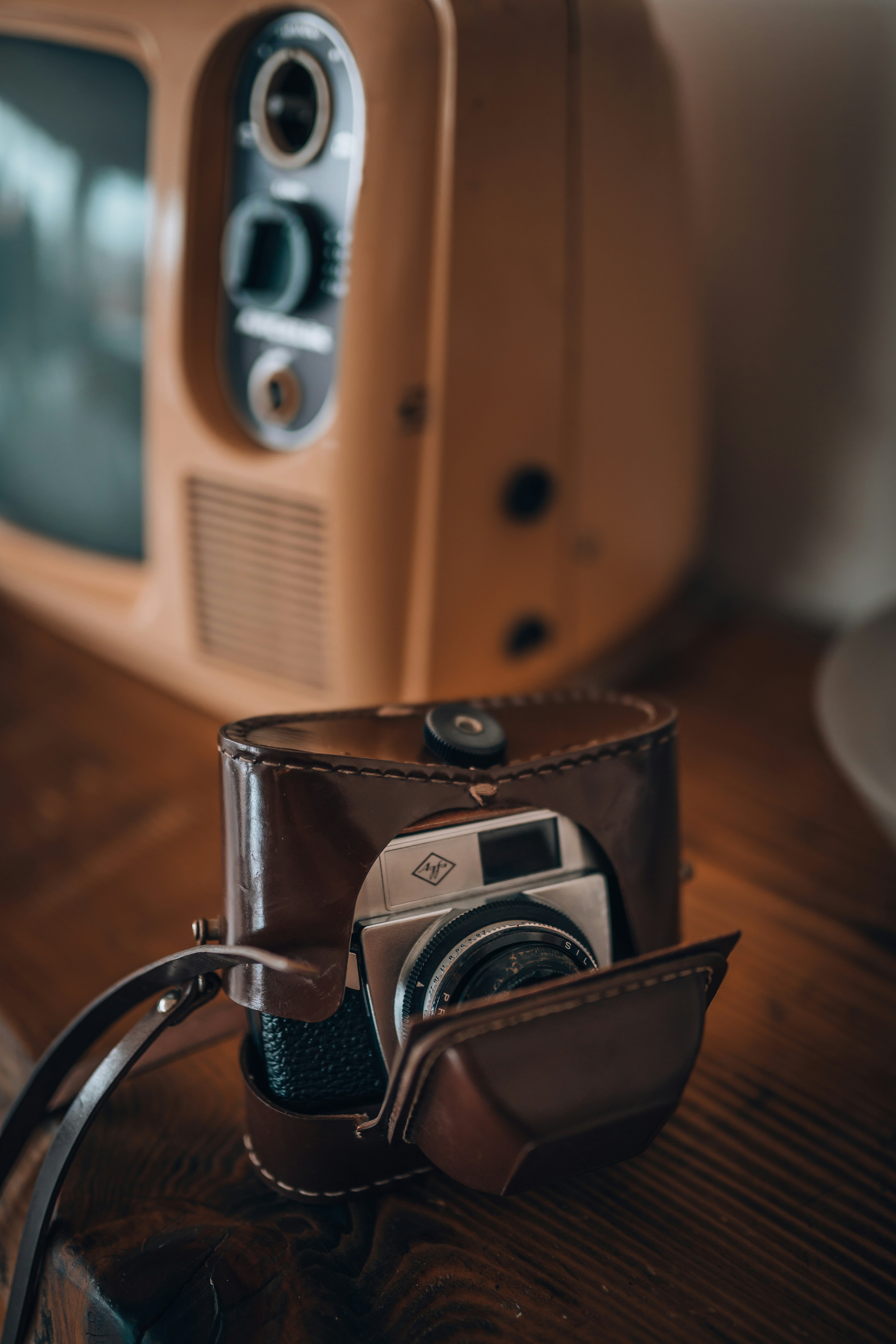 Leather-Wrapped Rangefinder Resting Before a Retro Monitor