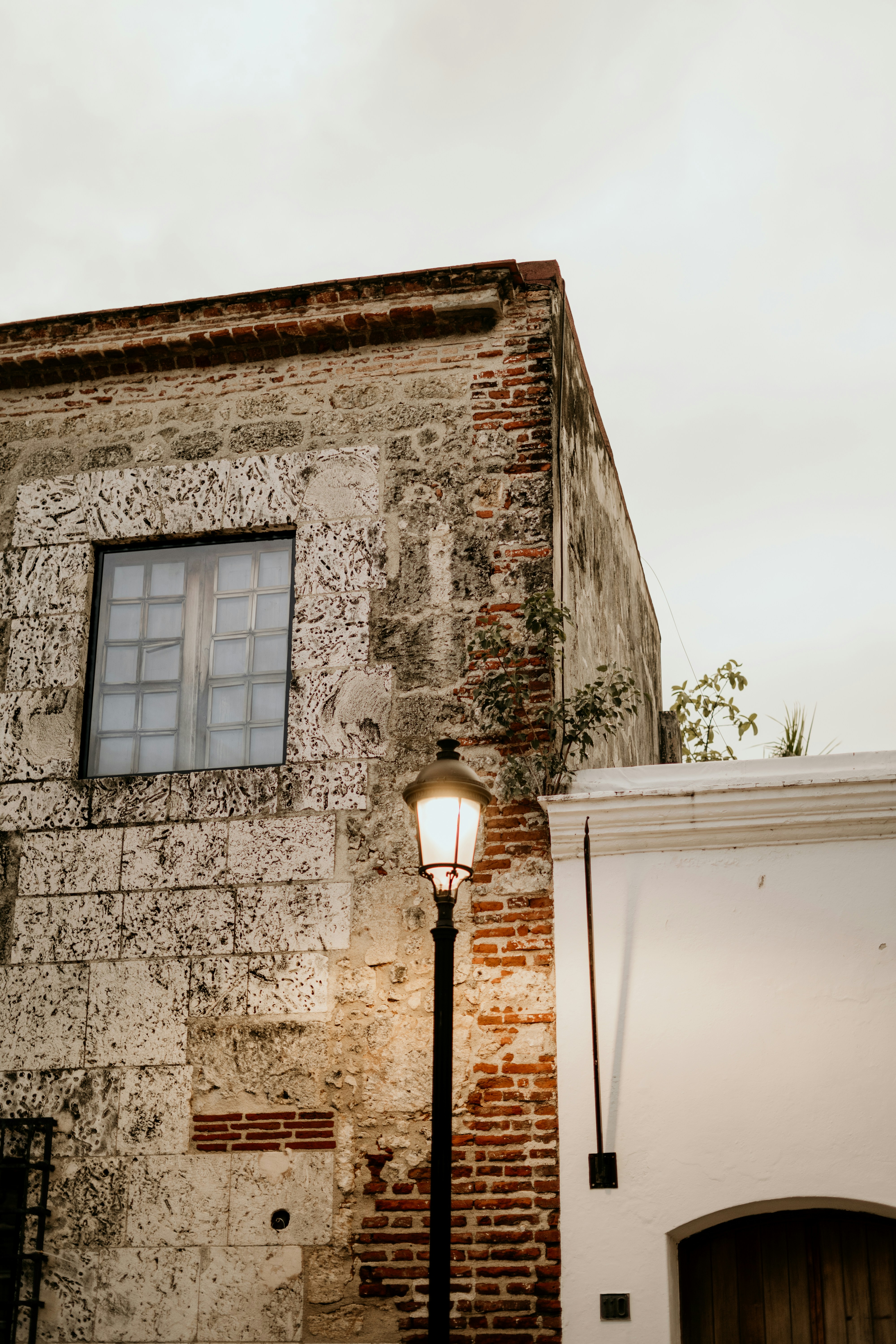 An old brick building with a street light in front of it photo – Free ...
