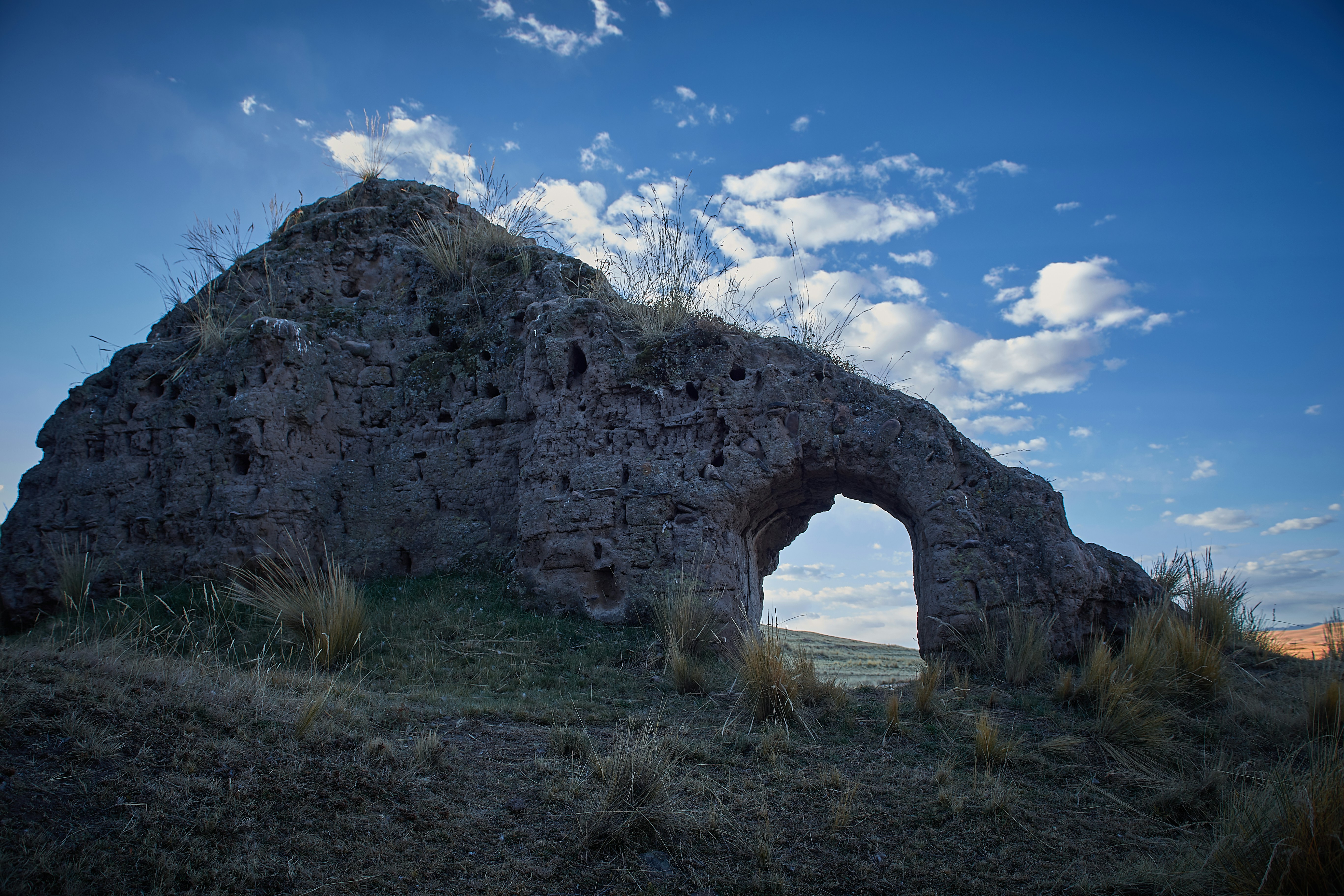 Stone Arch at the Edge: Desert Gateway Under a Wide Blue Sky