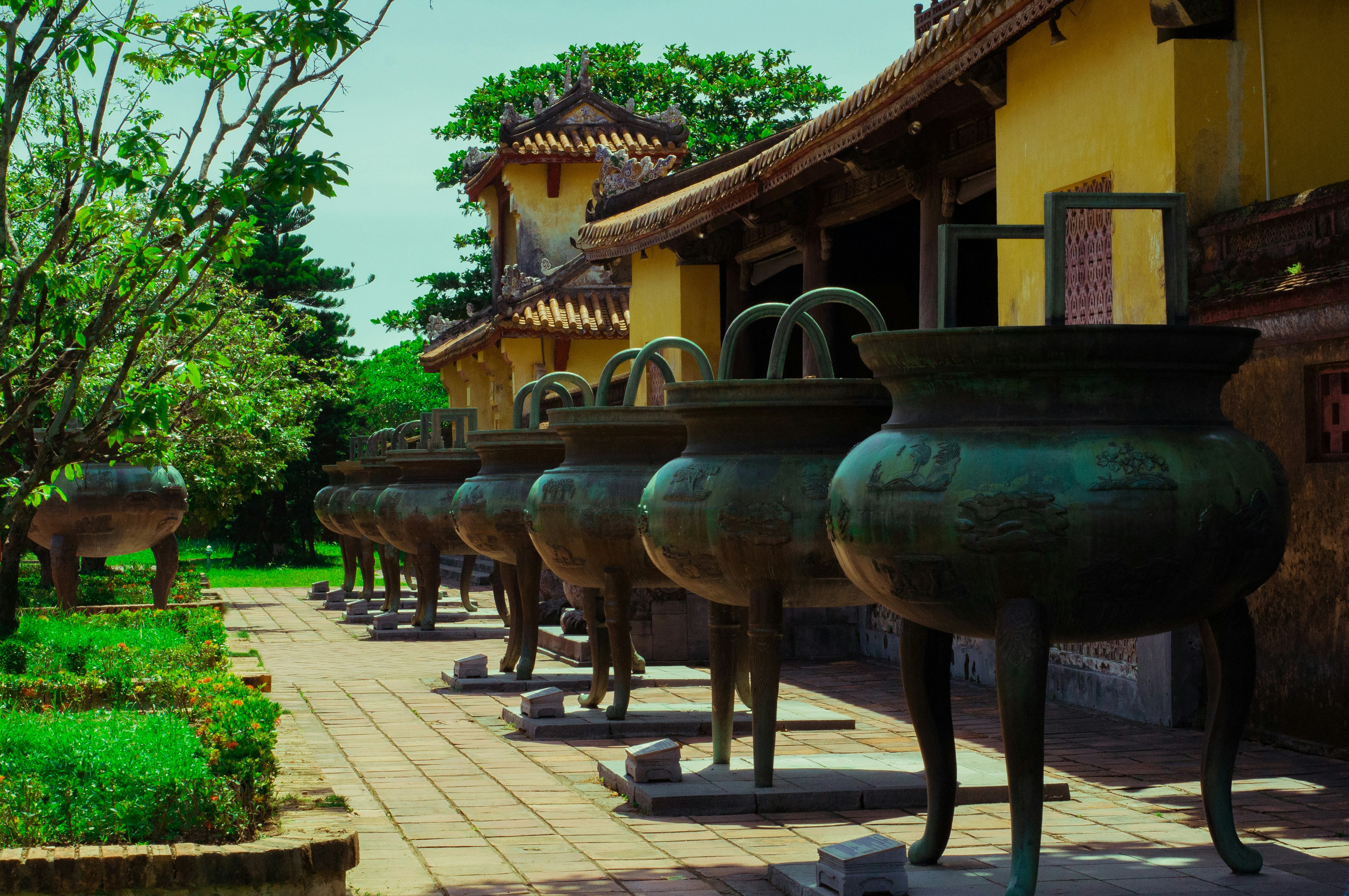Bronze Urns in Sunlit Corridor: Guardians of a Temple Path