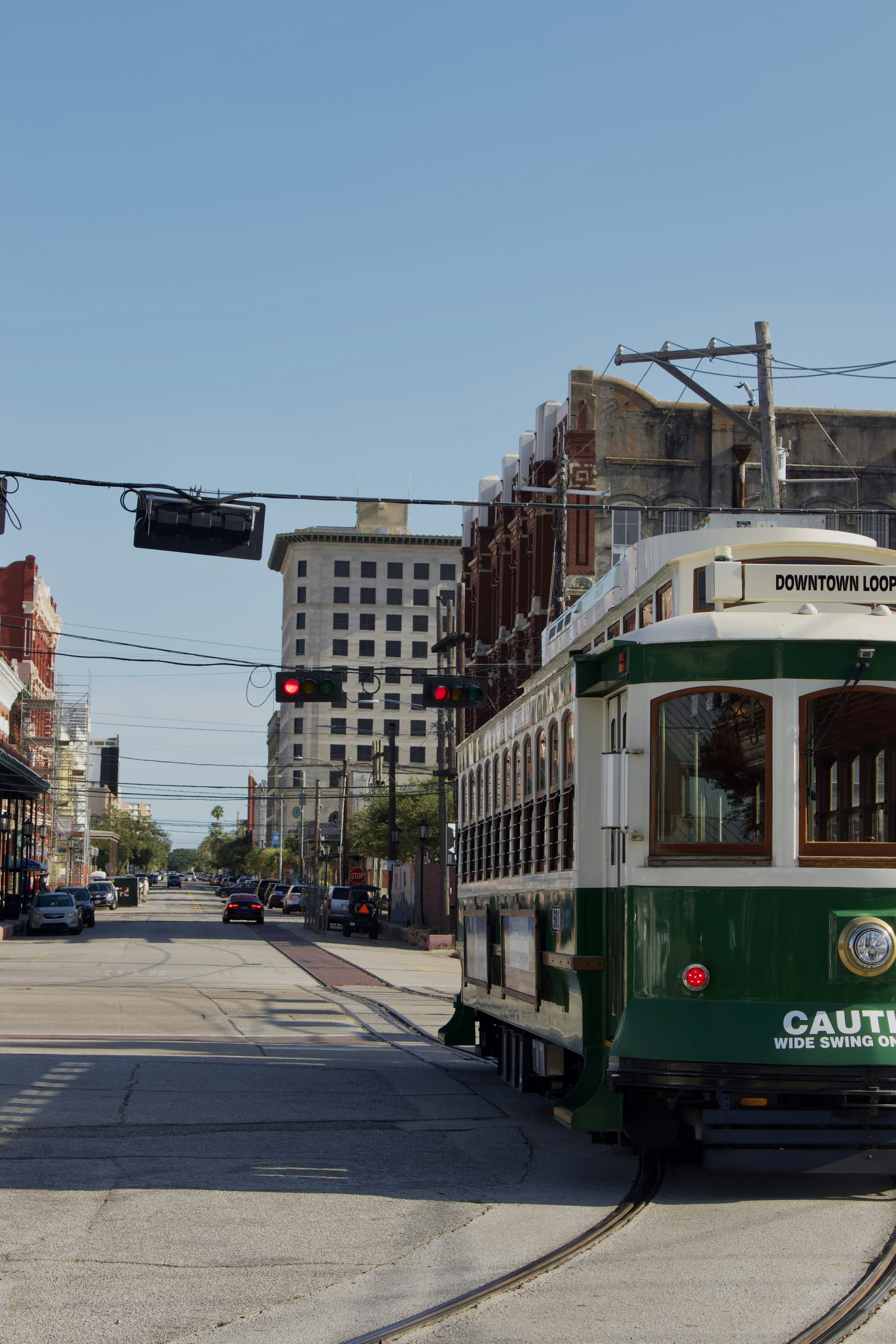 A green and white trolley on a city street photo – Free Lights Image on ...