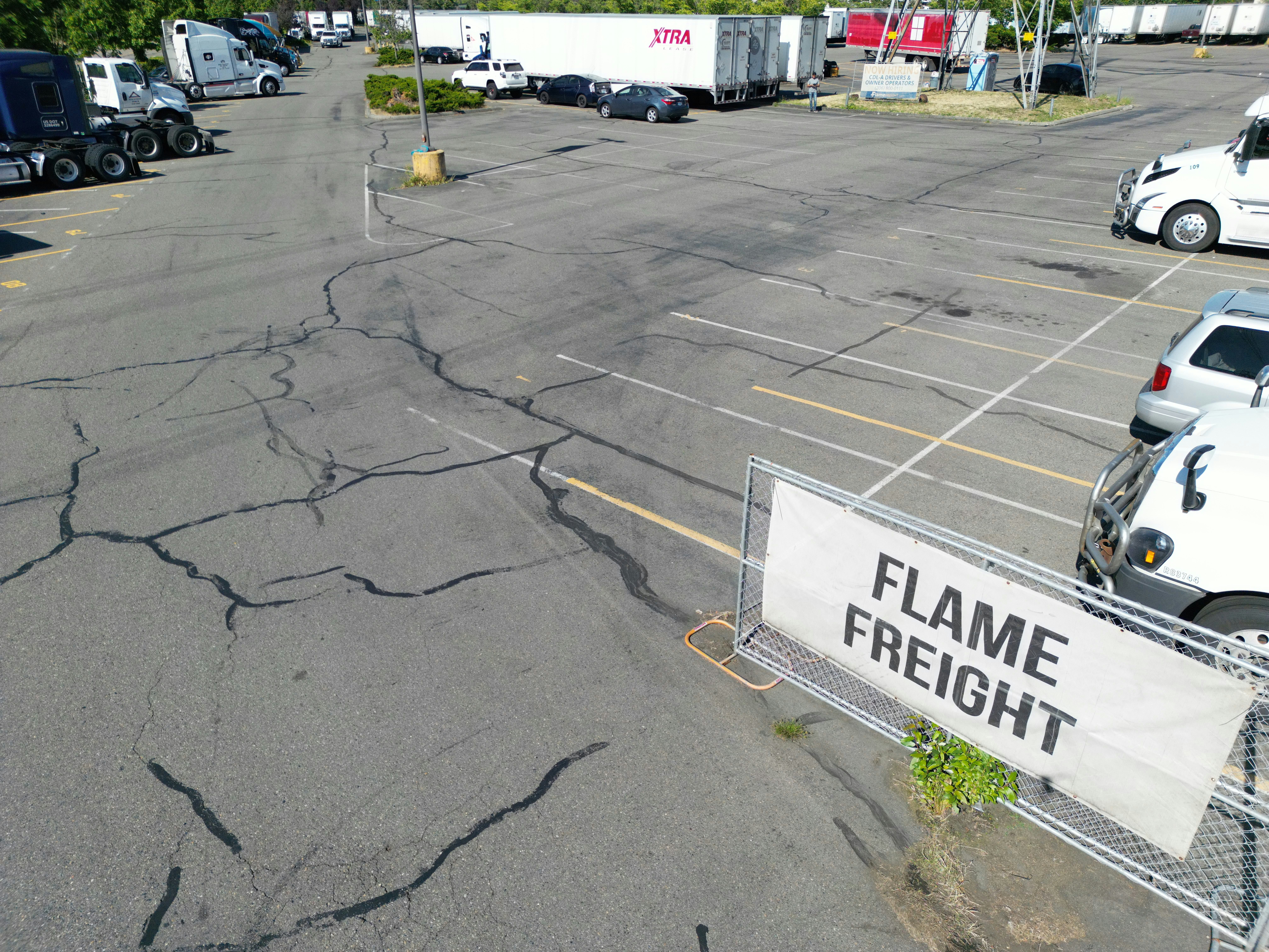 Parking lot with a Flame Freight sign and several trucks lined up.