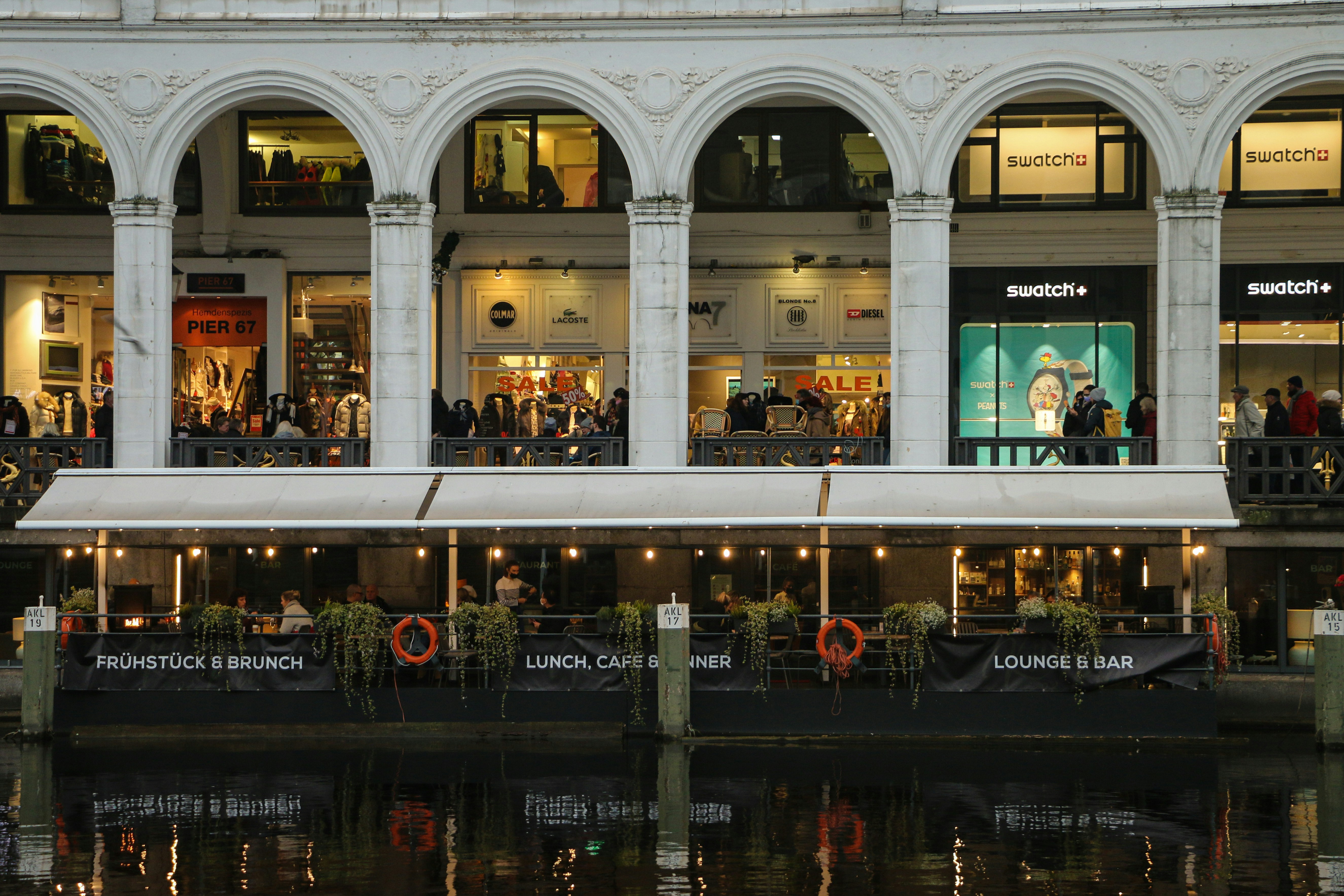 Canalfront Arcades: Arched Columns, Warm Lights, and Water Reflections