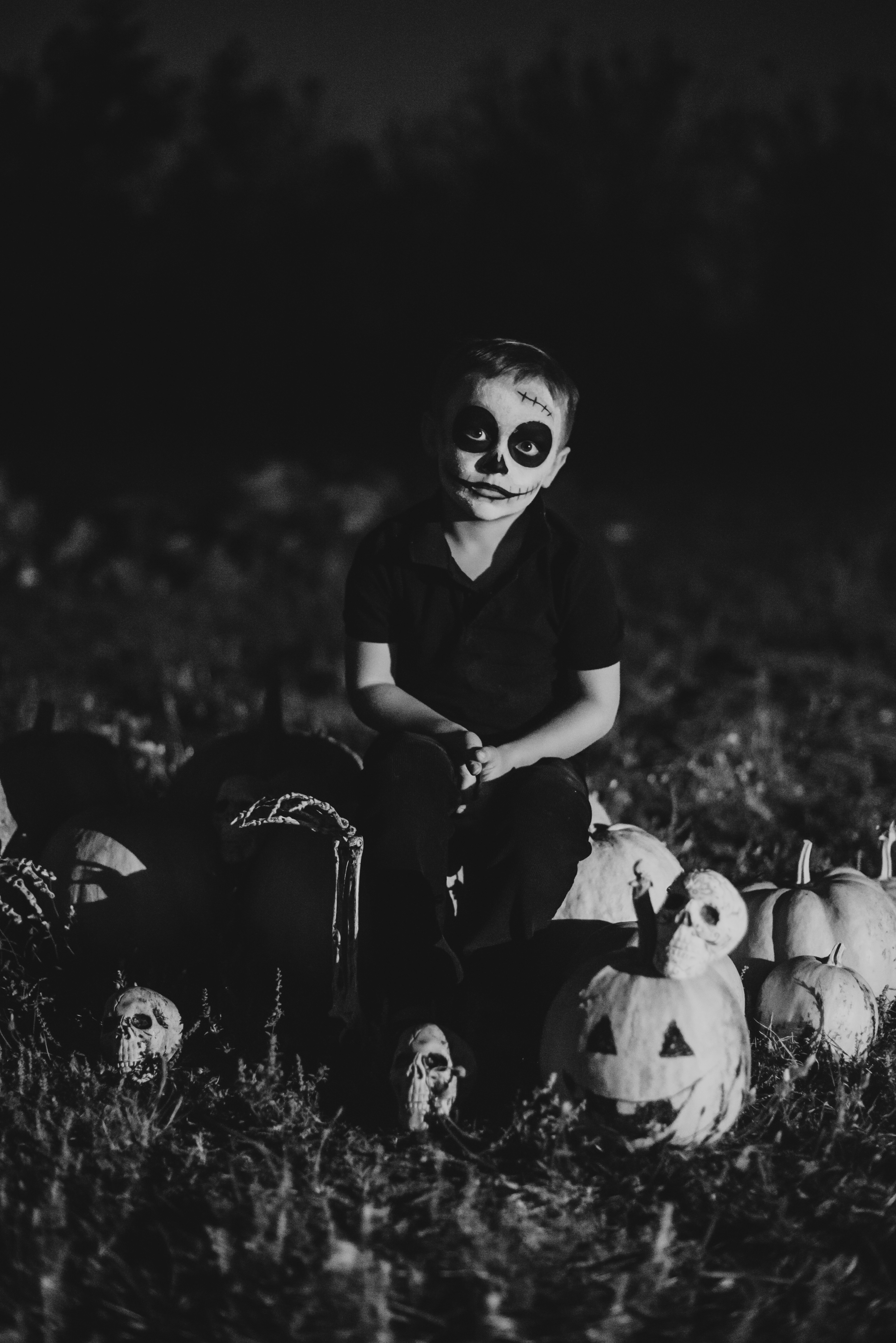 Face Painted in Moonlight: A Halloween Child Among Jack-o'-Lanterns in Noir