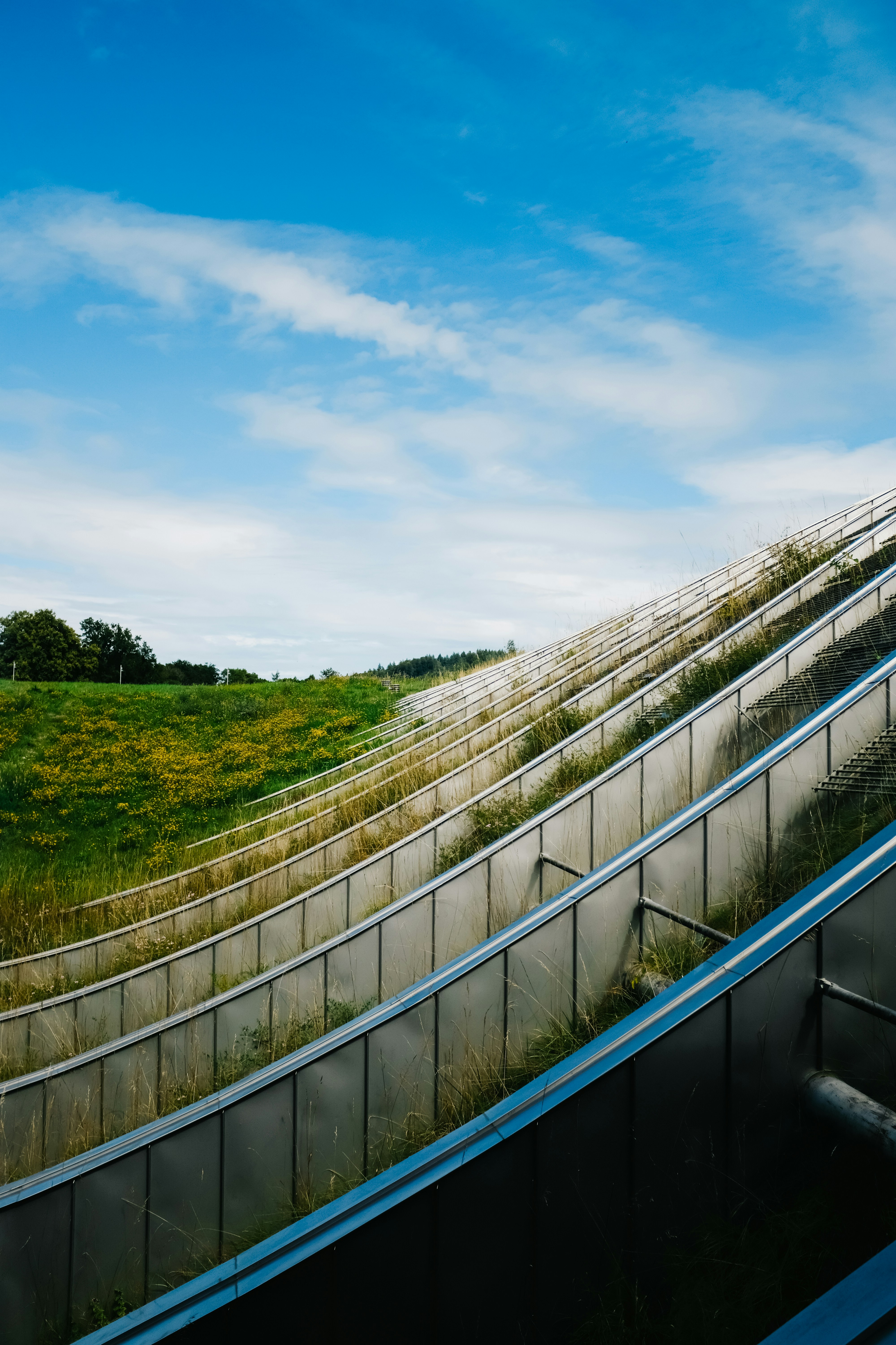 A row of empty escalators in a grassy field photo – Free Nature Image ...