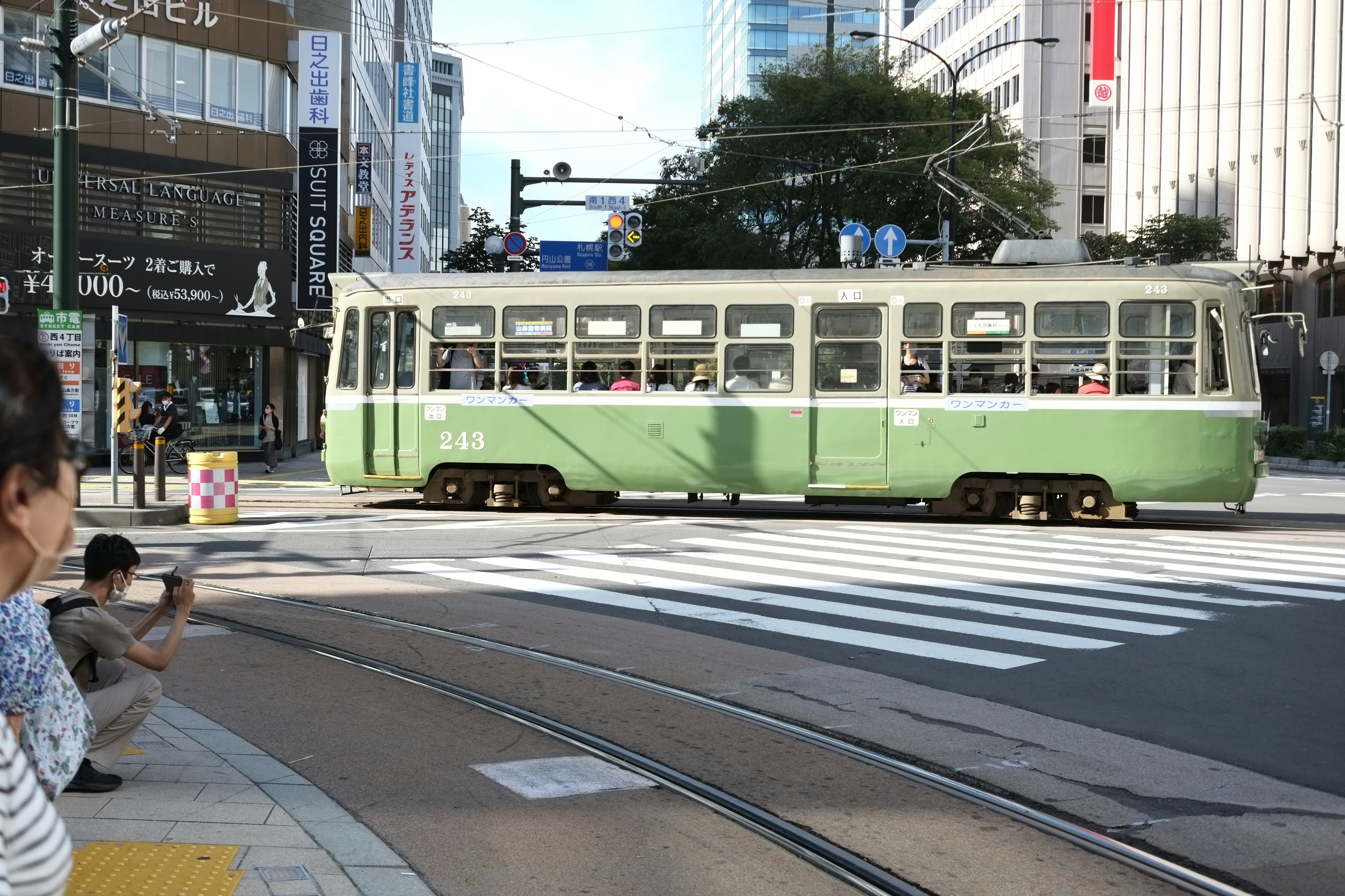 A woman taking a picture of a green trolley photo – Free Car Image on ...