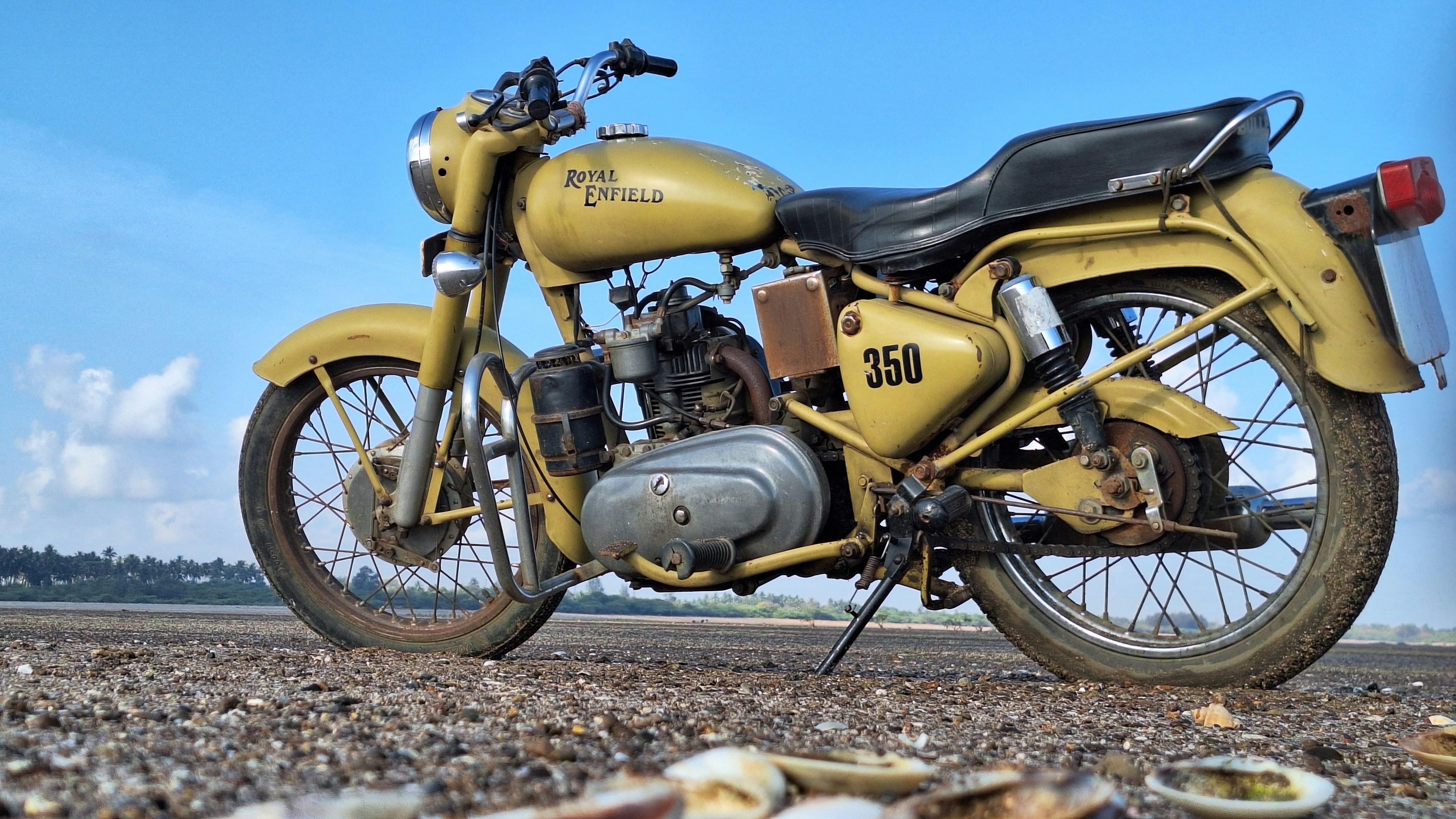Sunlit Vintage Royal Enfield on a Pebble Beach