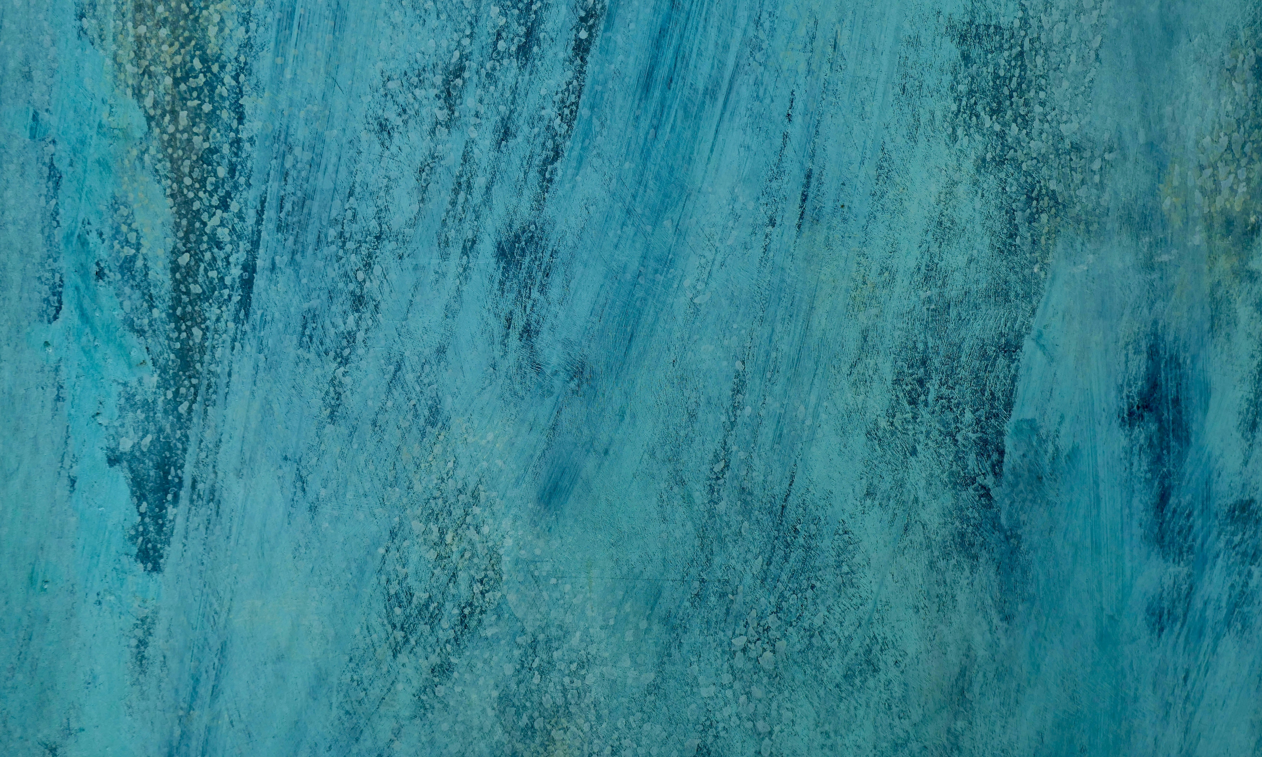Abstract painting with swirling shades of blue and hints of textured patterns.