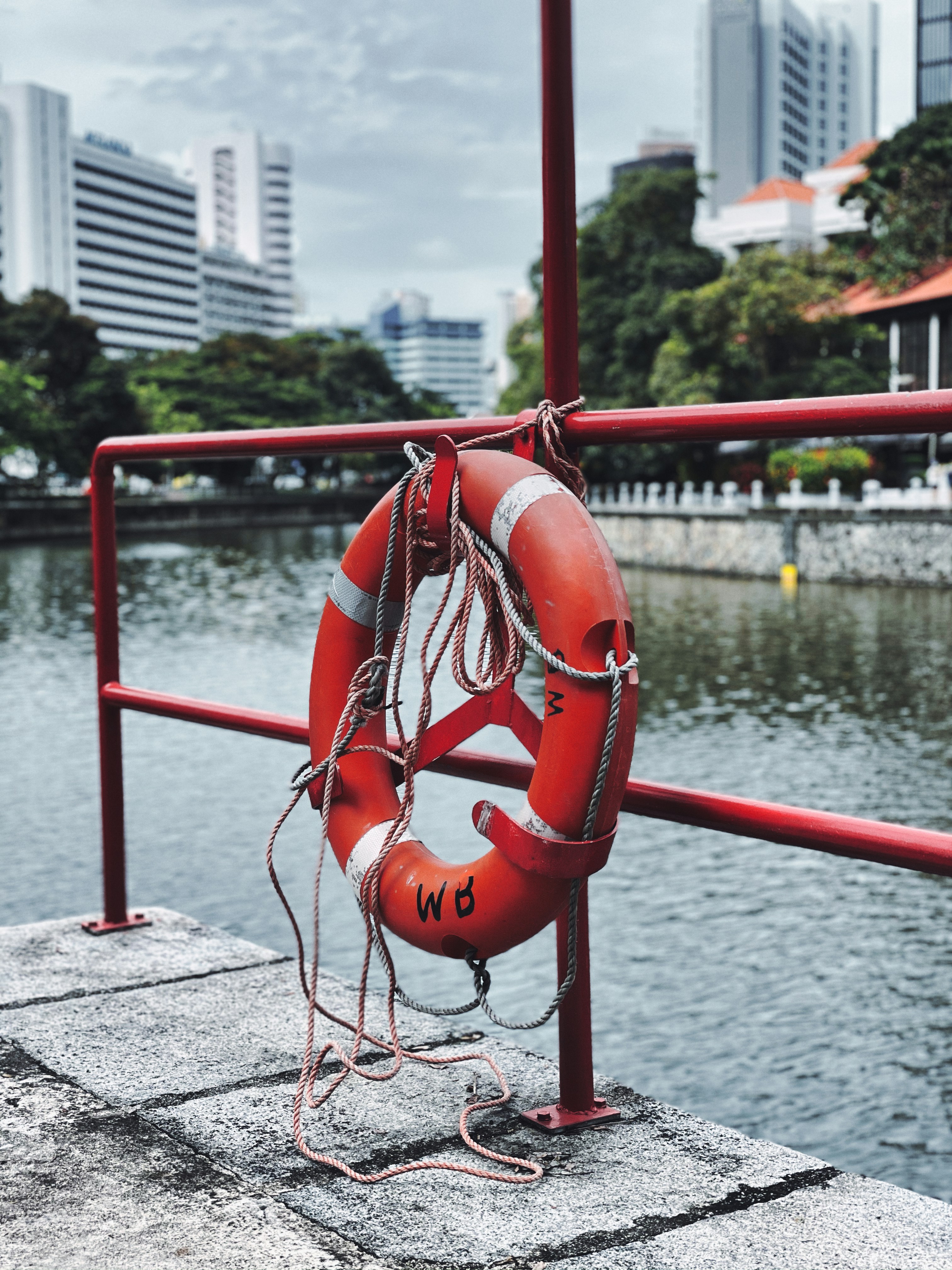 Crimson Lifebuoy at the Edge of the City Canal