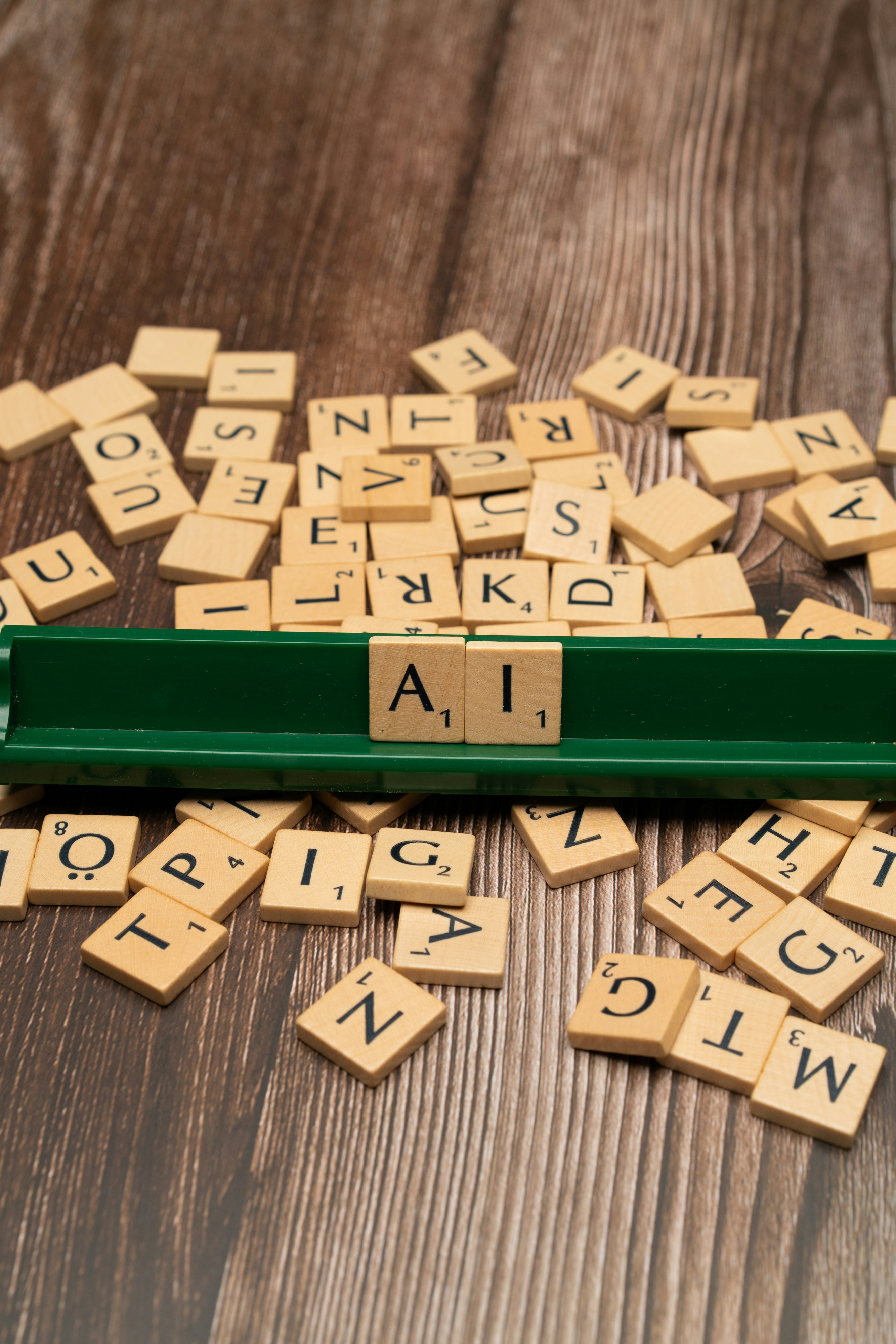 Scrabble tiles spelling out the word ai on a wooden table photo – Free ...