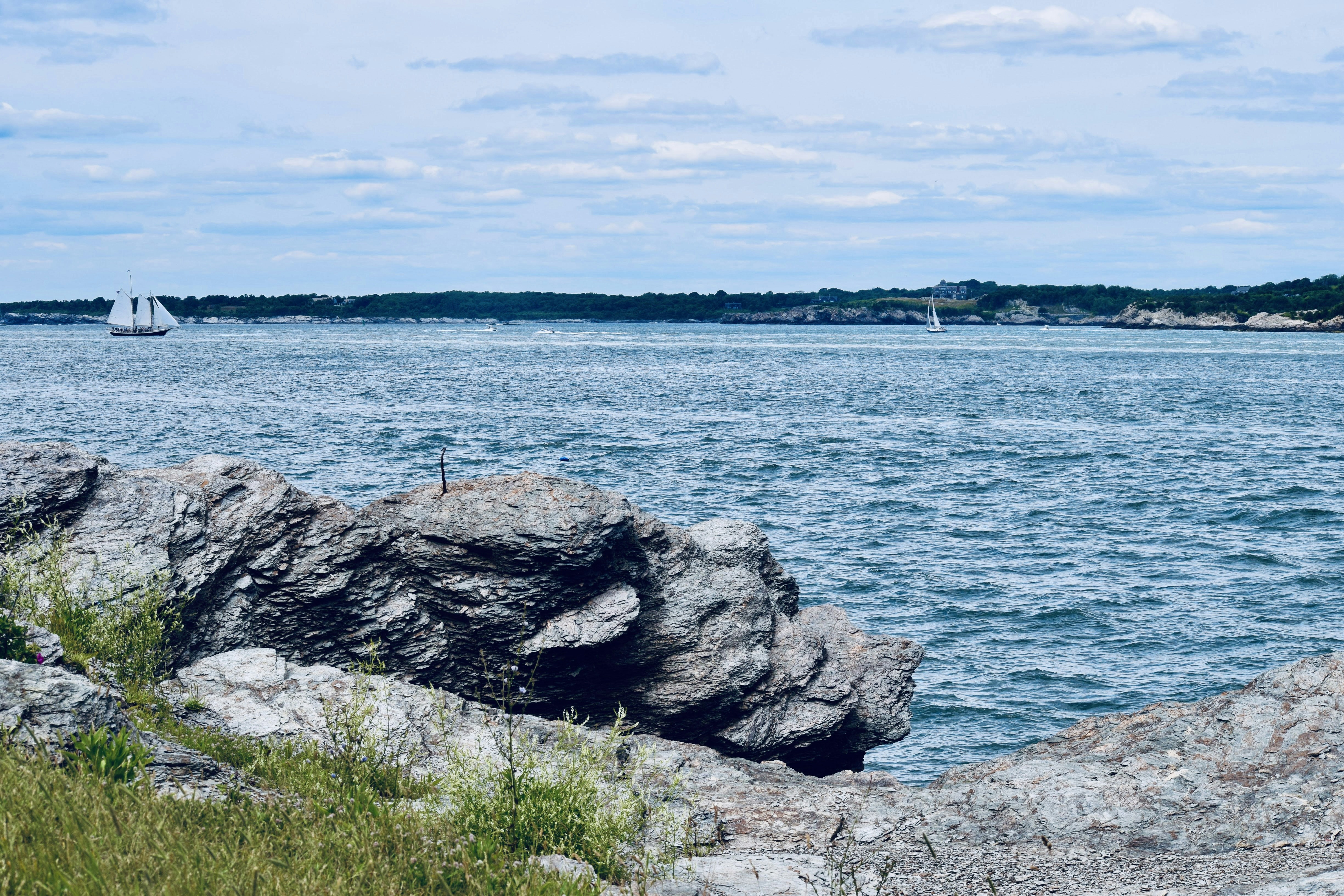 A large body of water sitting next to a rocky shore photo – Free Rhode ...
