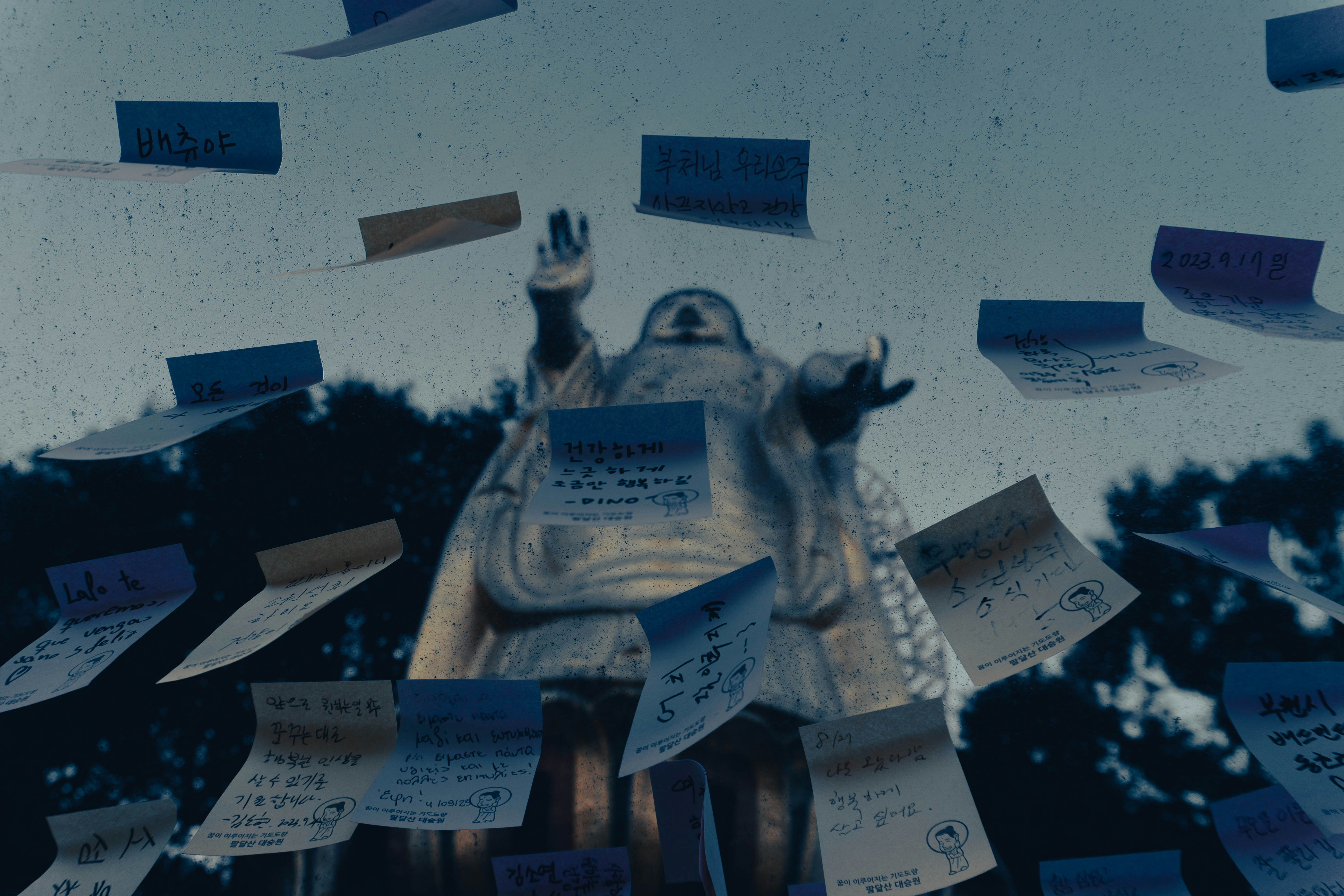 Notes in the Air: A Statue Beneath a Rain of Messages