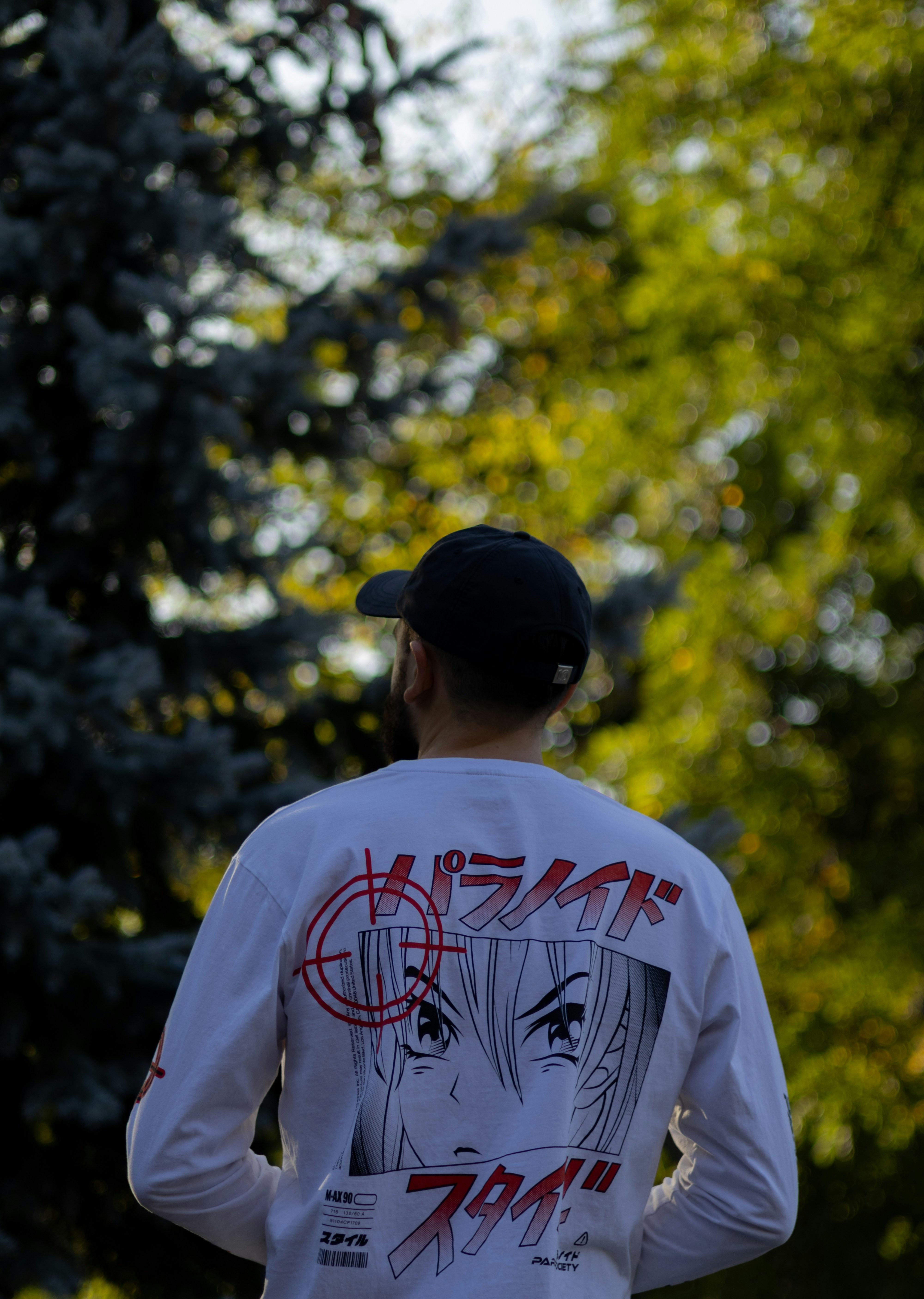 Backside in Bloom: White Tee with an Illustrated Manga Graphic in a Sunlit Park