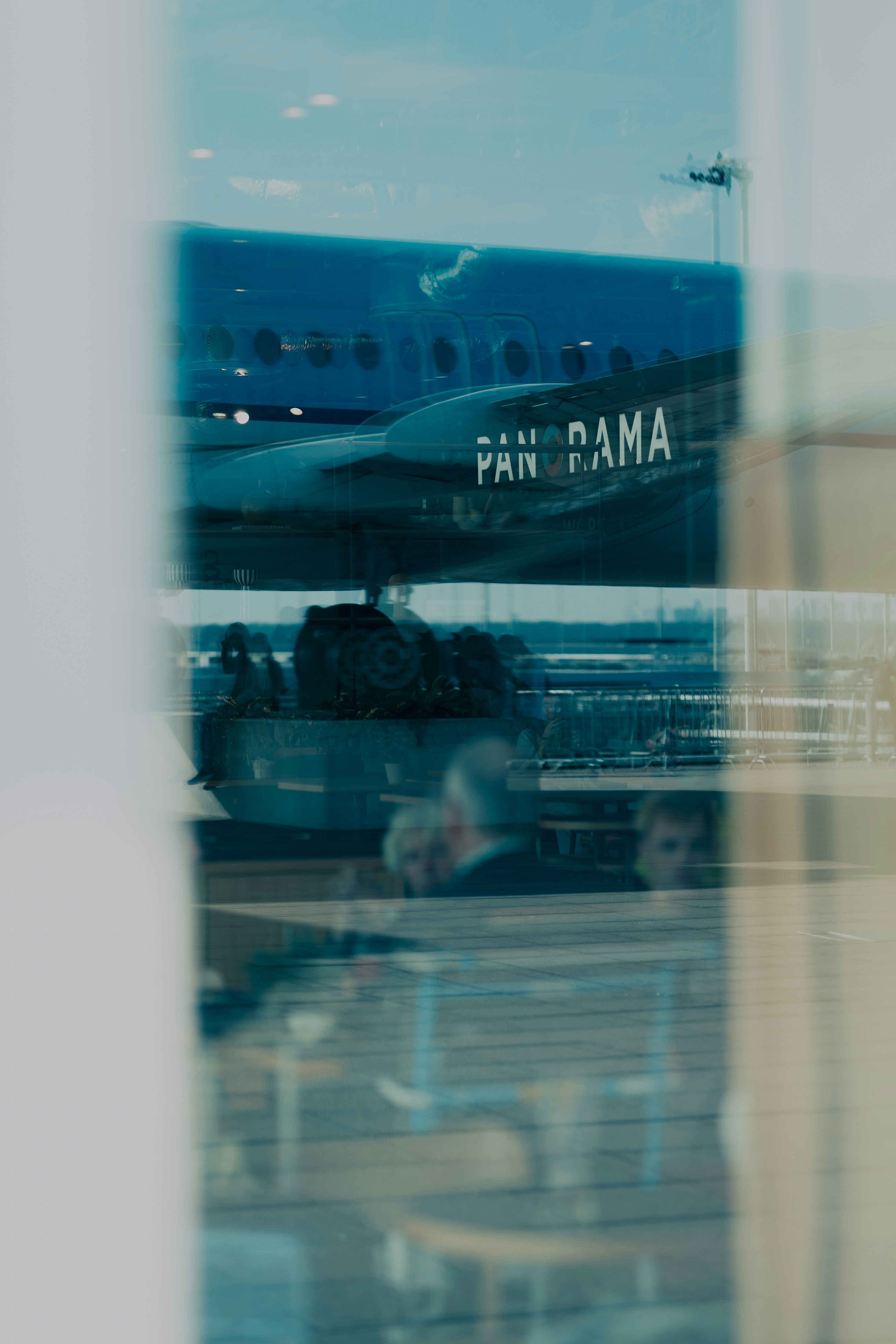 Blue Glass Echo: A Passenger Jet Reflected in Terminal Windows