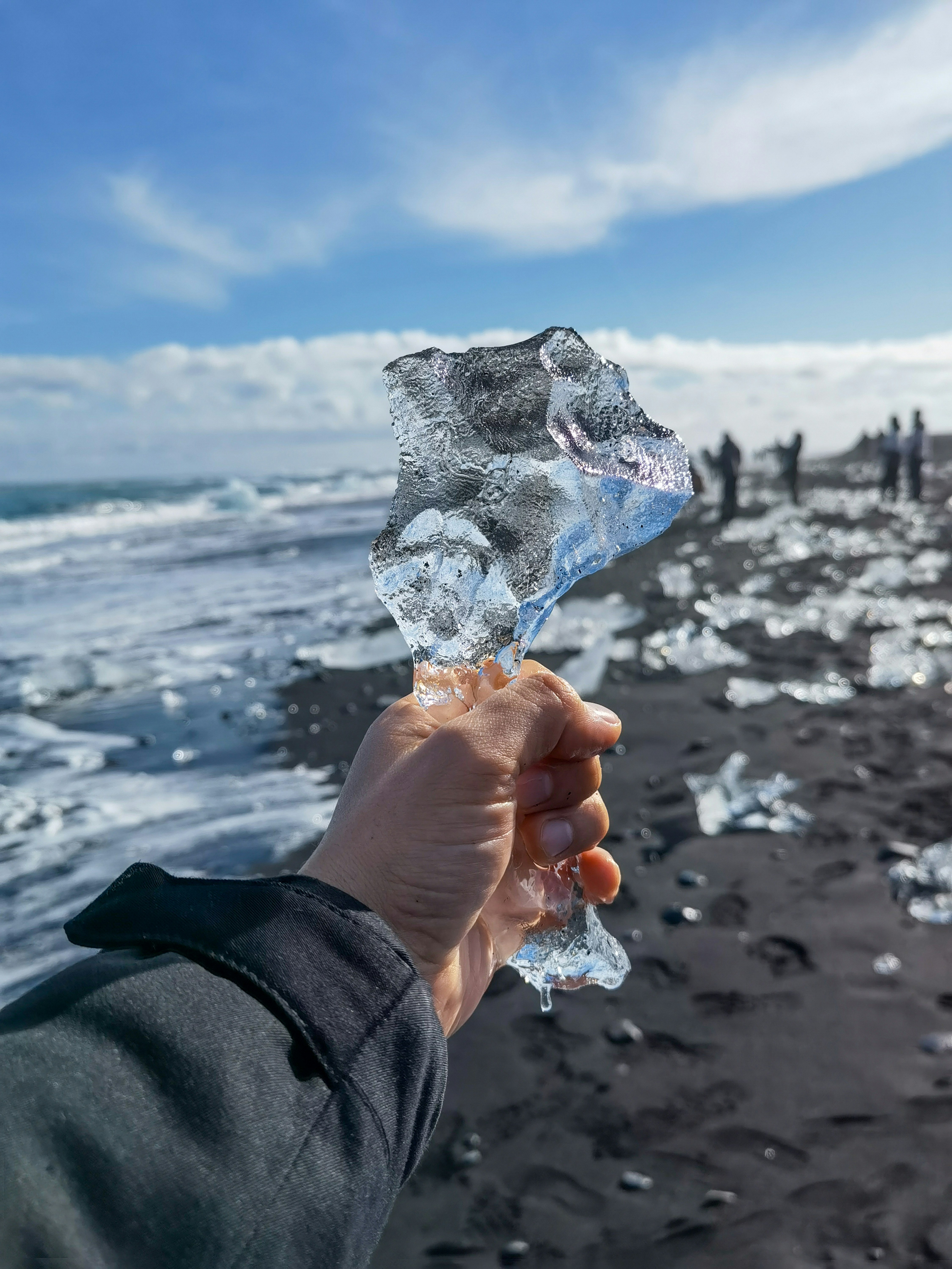 Ice shard in hand: a coastal moment captured in daylight