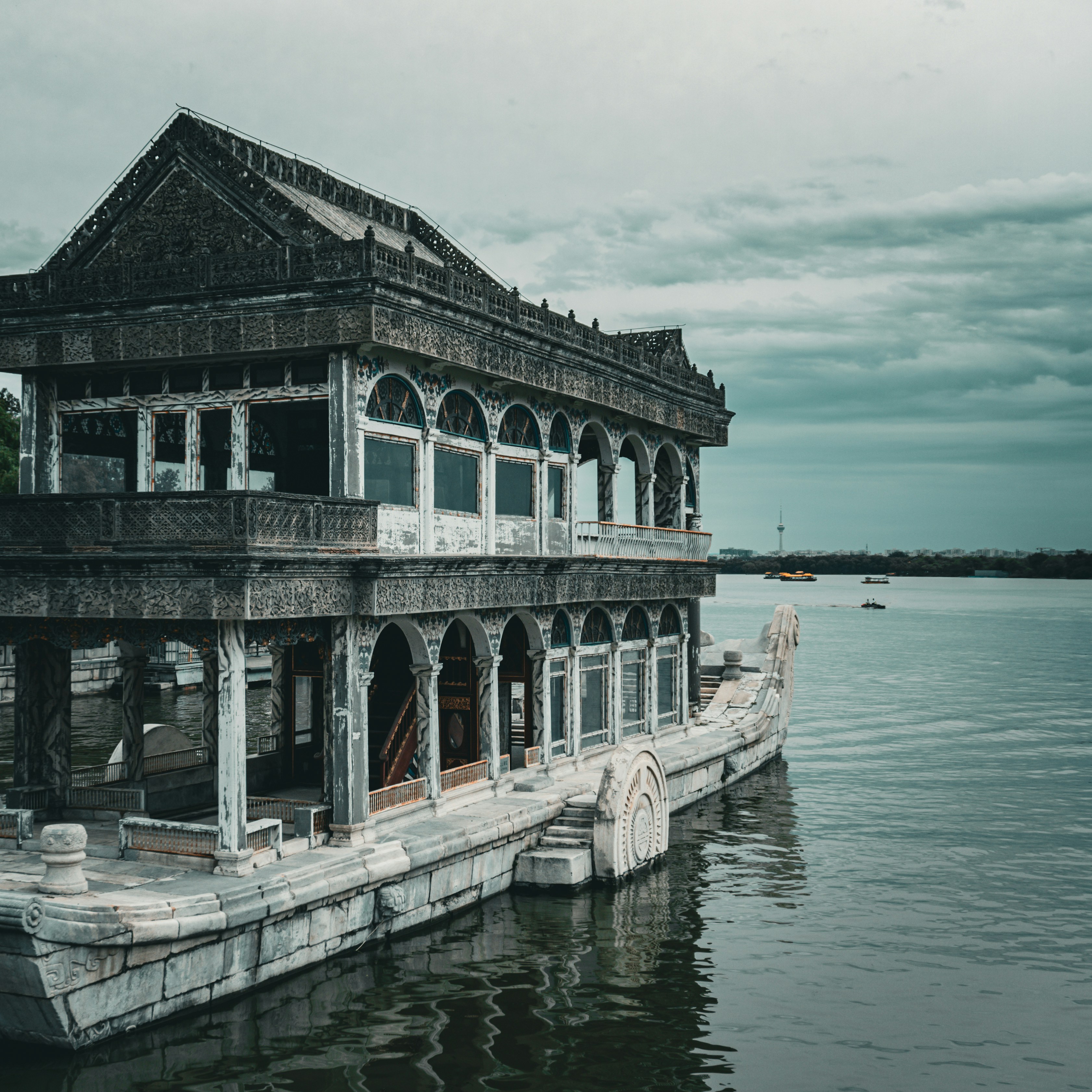 Arched Waterfront Pavilion: Weathered Stone Reaching into a Calm Lake