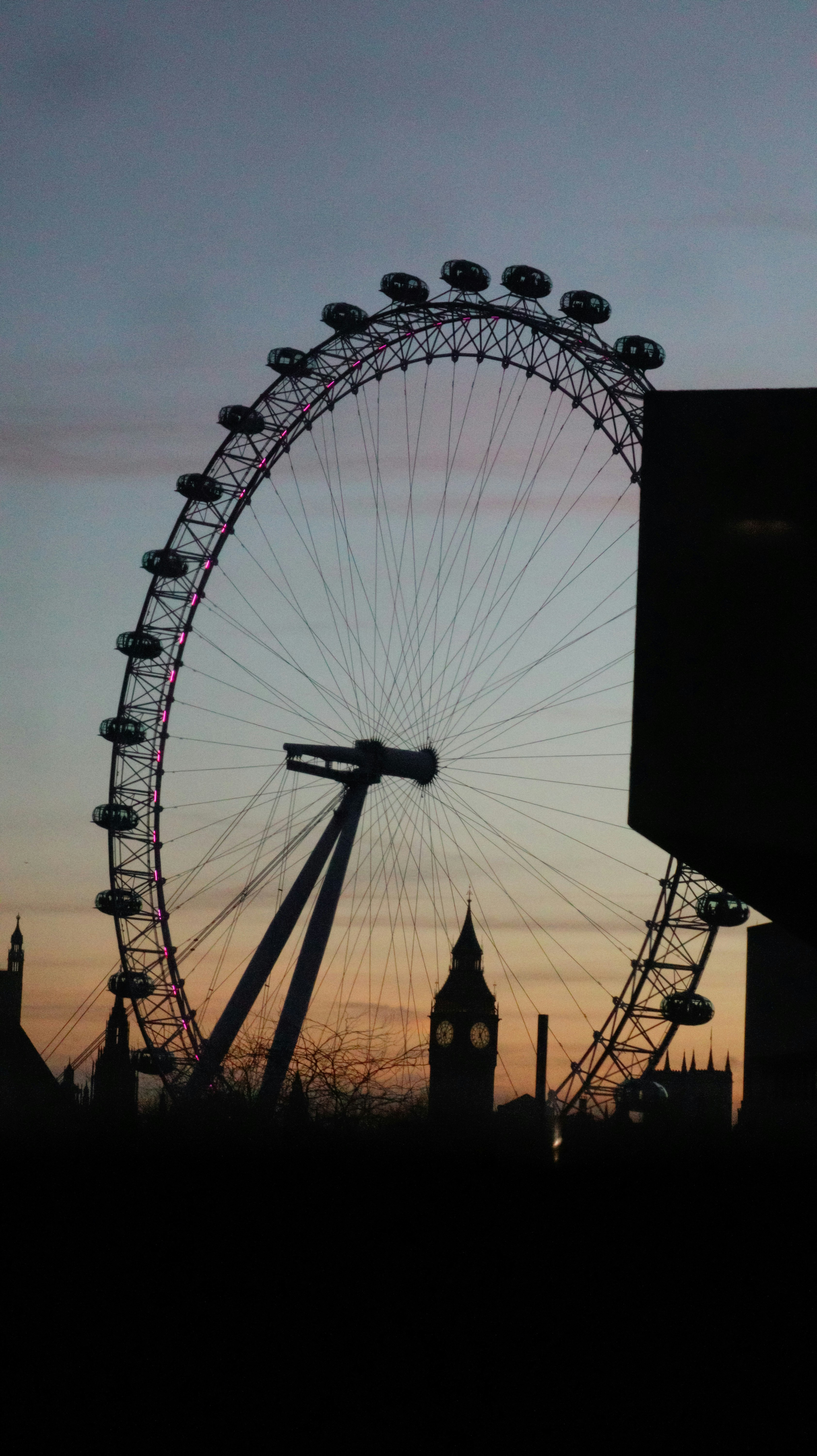A large ferris wheel sitting next to a tall building photo – Free ...