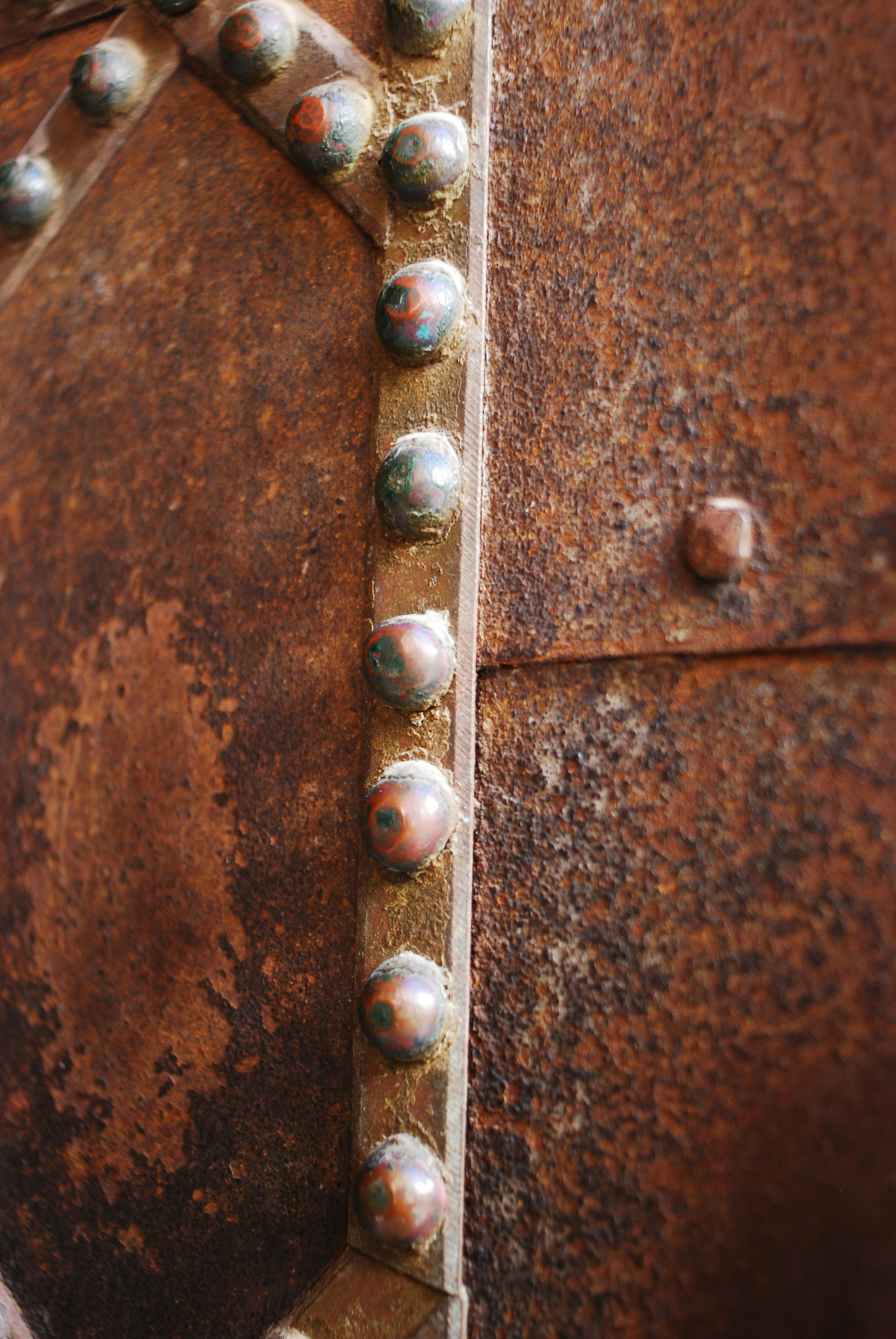 A rusted metal surface with rivets and rivet holes photo – Free Door ...