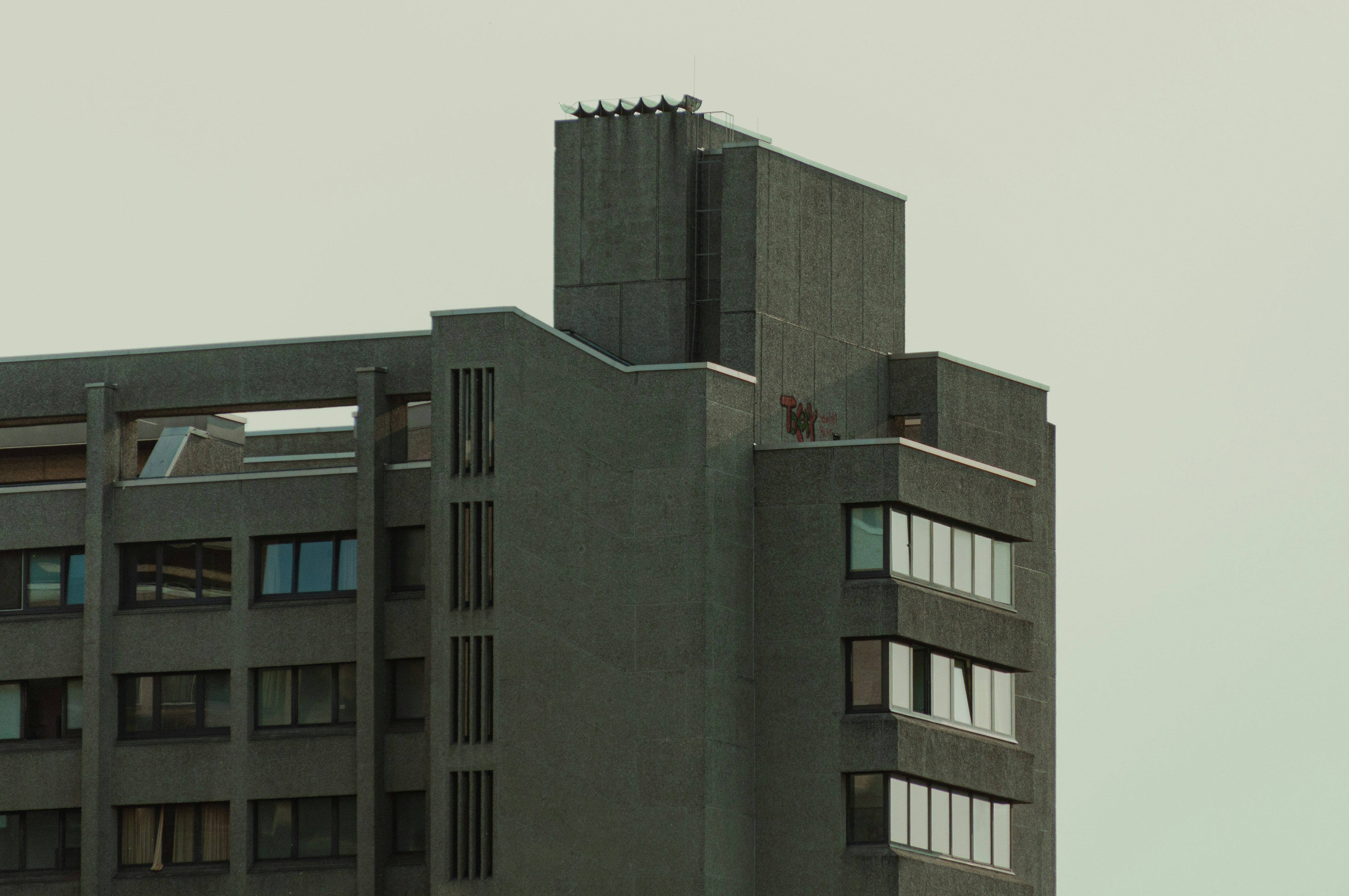 Concrete Monolith: Towering Corner Against a Pale Sky