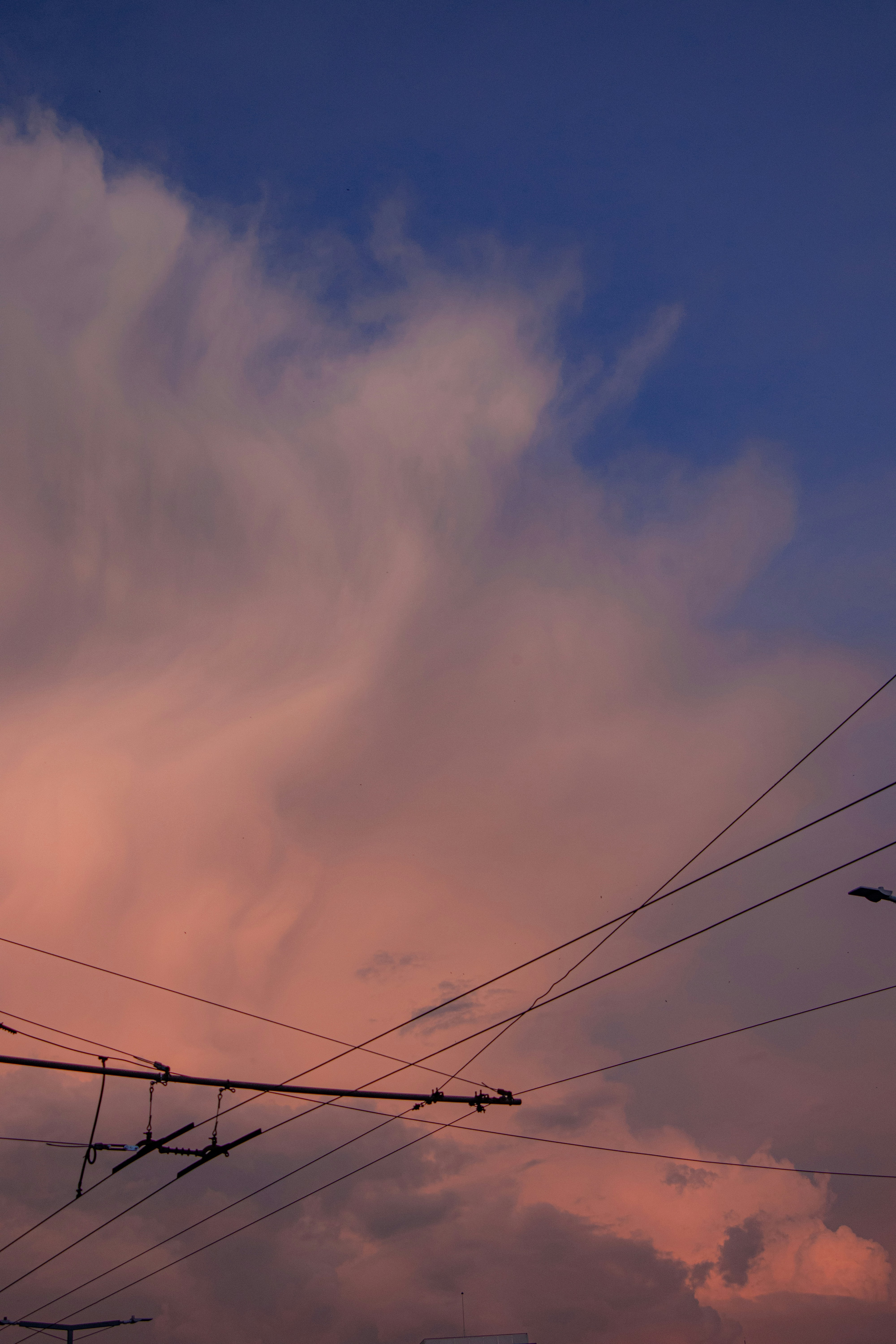 Twilight Currents: Pink Clouds Framed by Crisscrossed Wires
