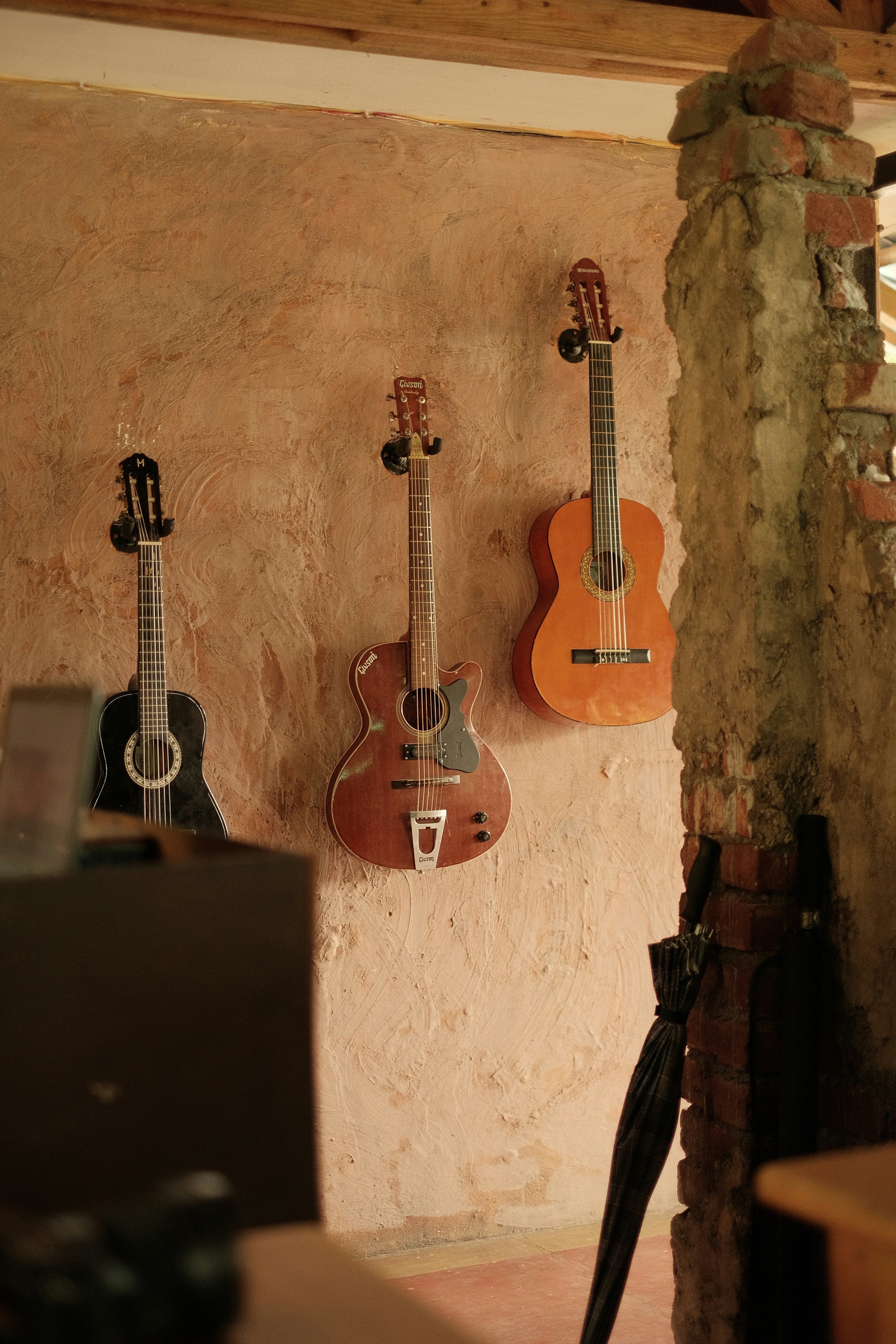 Hanging Harmonies: A Rustic Trio of Guitars in Soft Light
