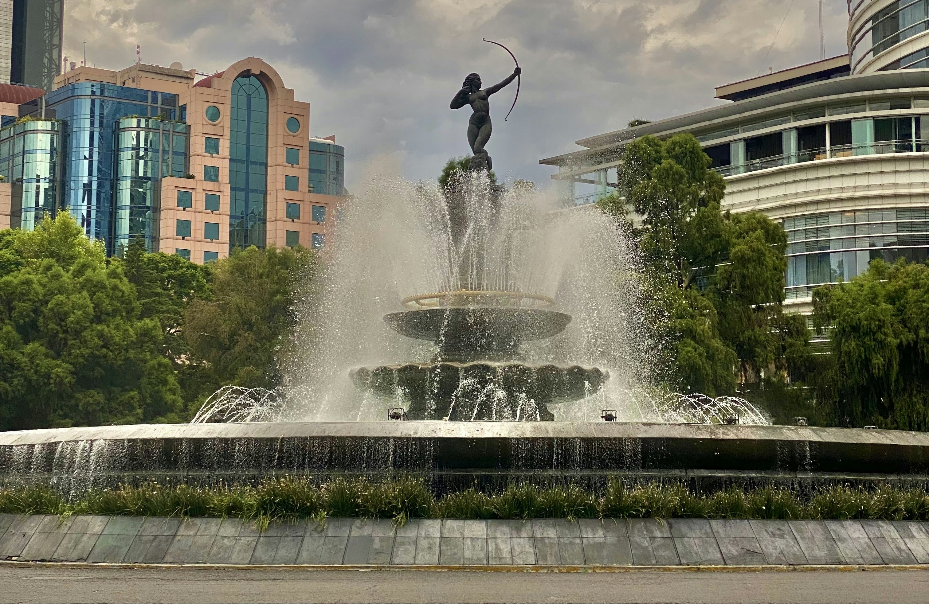 A water fountain with a statue of a man holding a bow photo – Free City ...